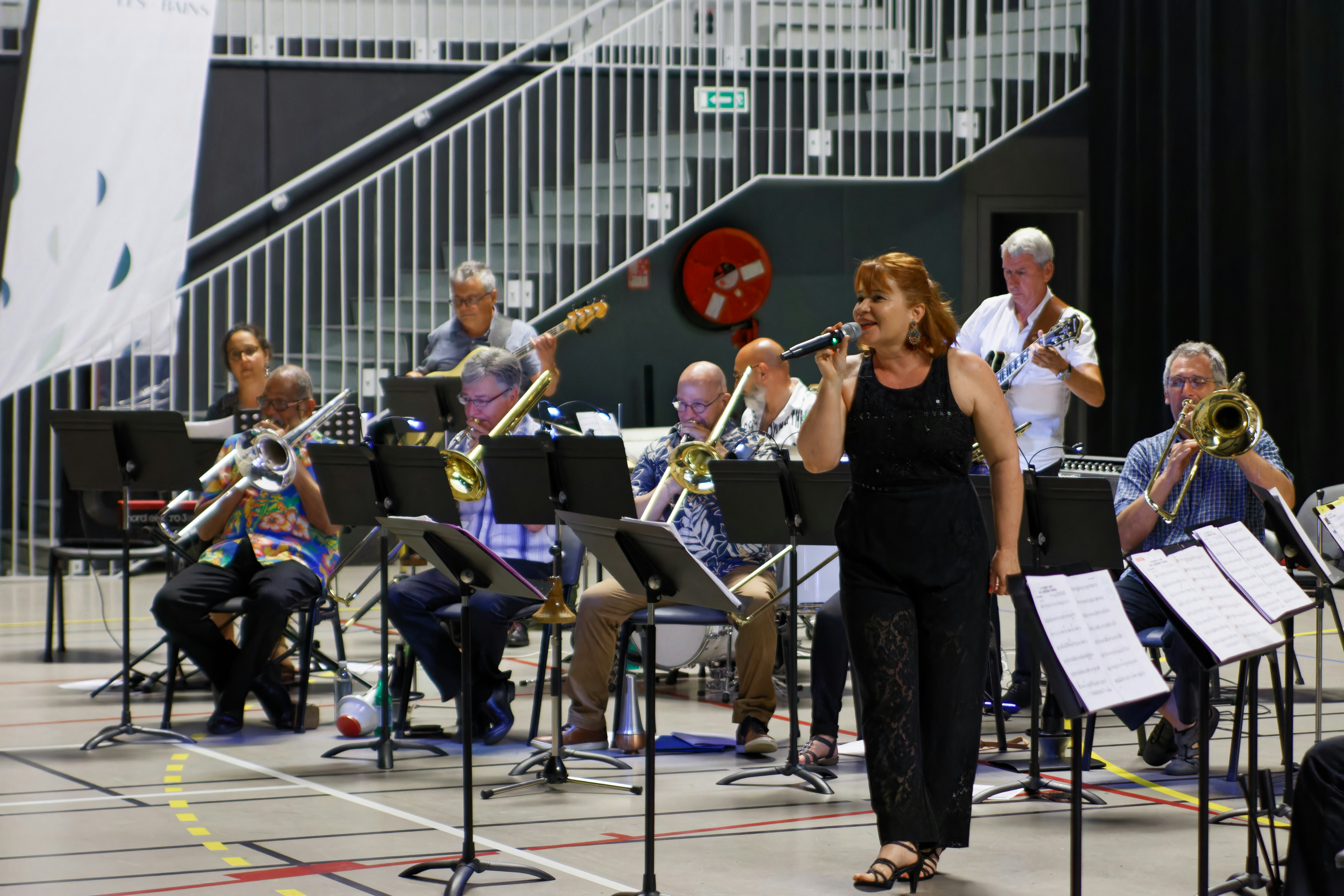 Mid-Show Melodies: A Vocalist Leads a Brass Ensemble in a Gym Annex