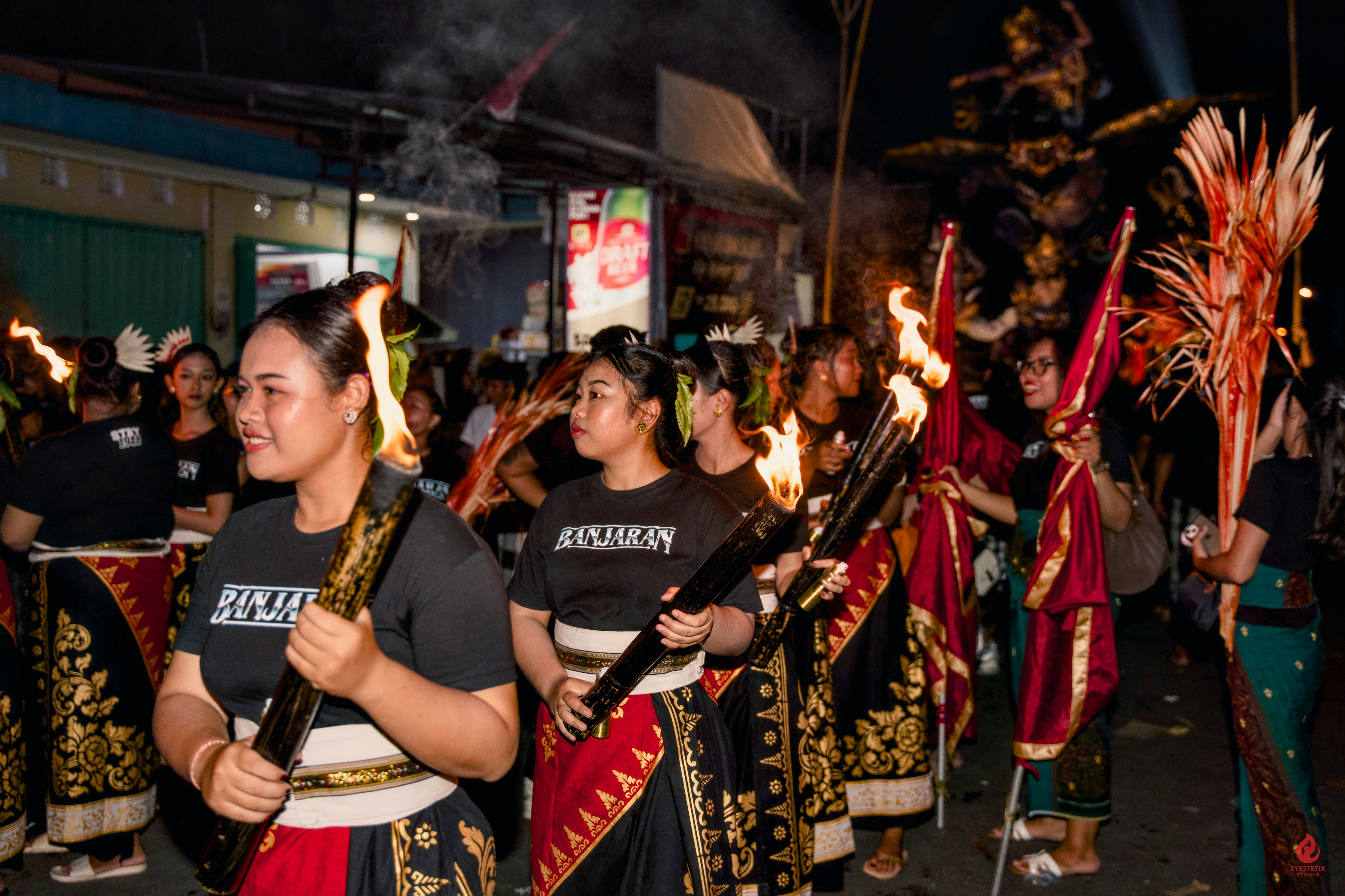 Torchbearers in Traditional Attire Lead a Night Parade