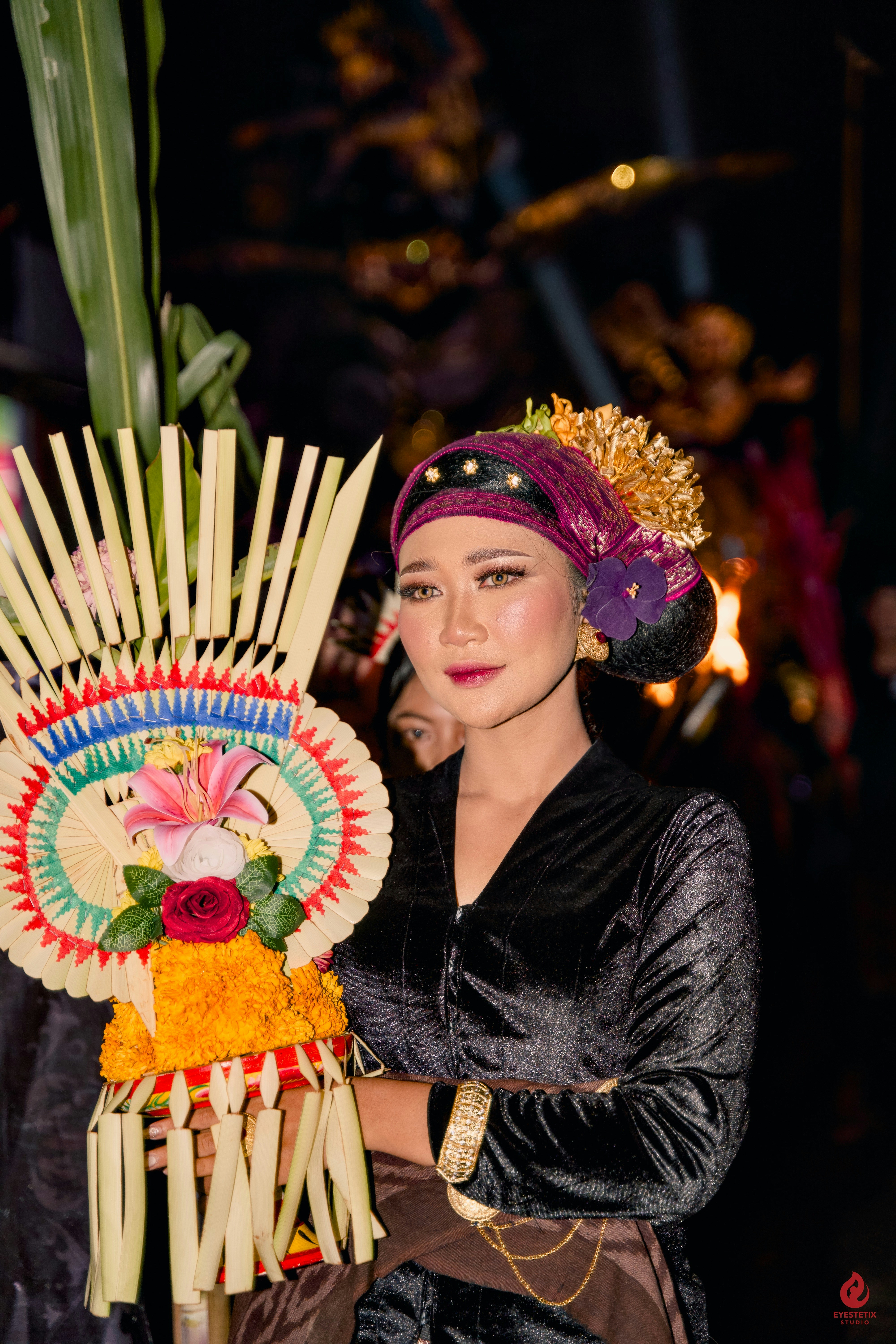 Portrait in Festive Attire: A Lady with Ornate Headdress and Handheld Decor