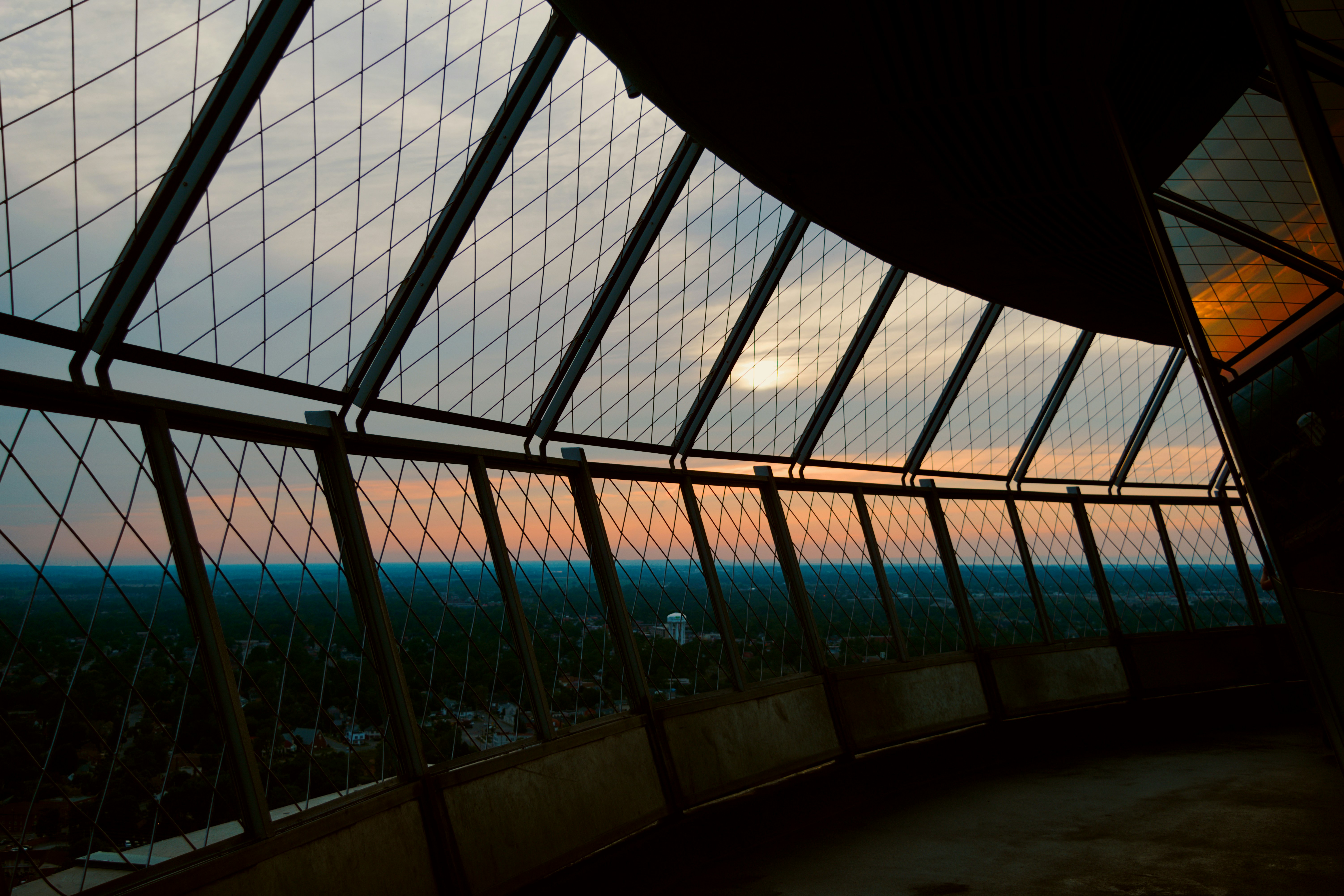Sunset Through a Glass Cathedral: A Rooftop Walkway Framed by Angular Glazing
