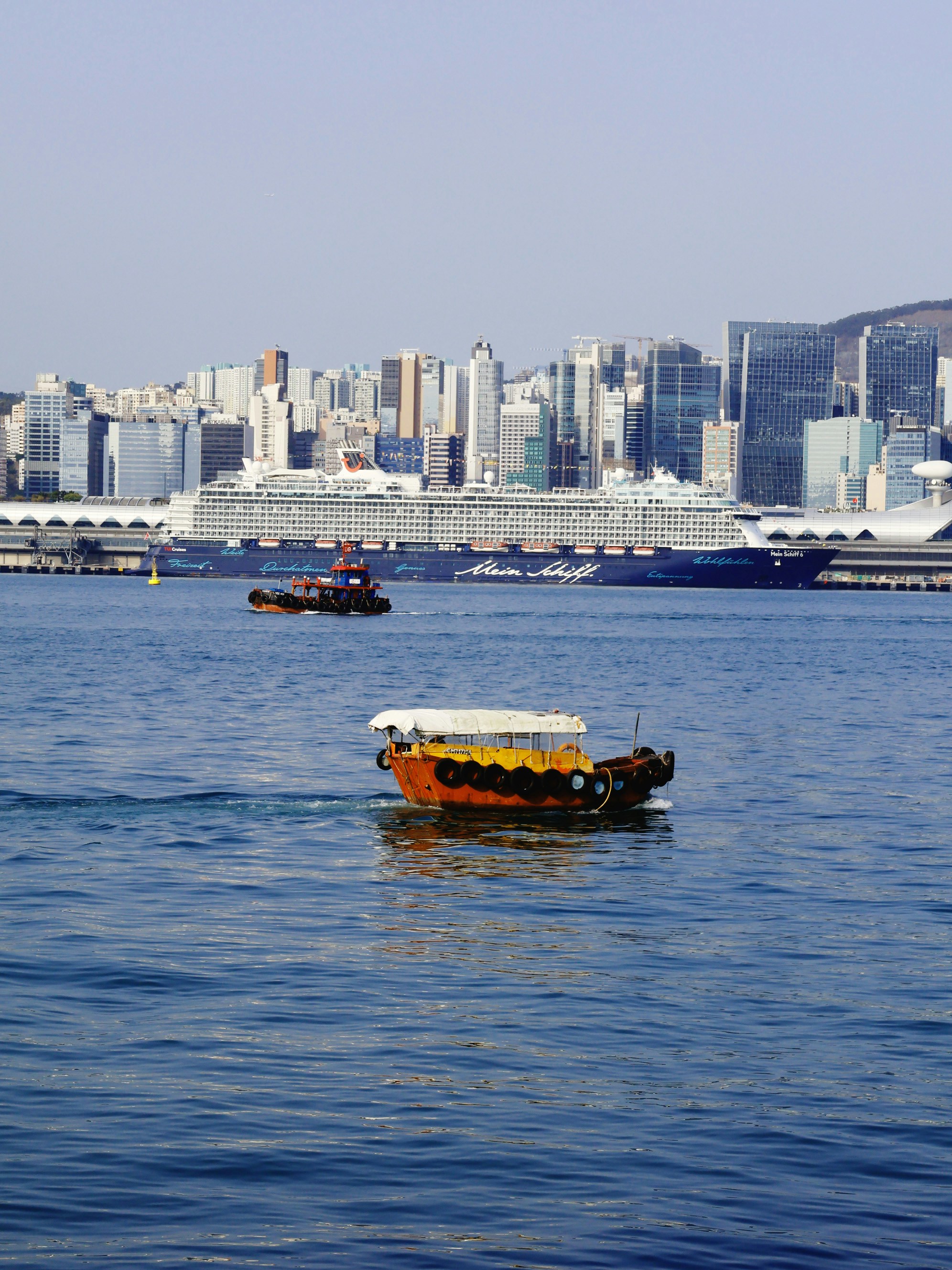 Orange Lifeboat on Calm Harbor with Skyline Backdrop