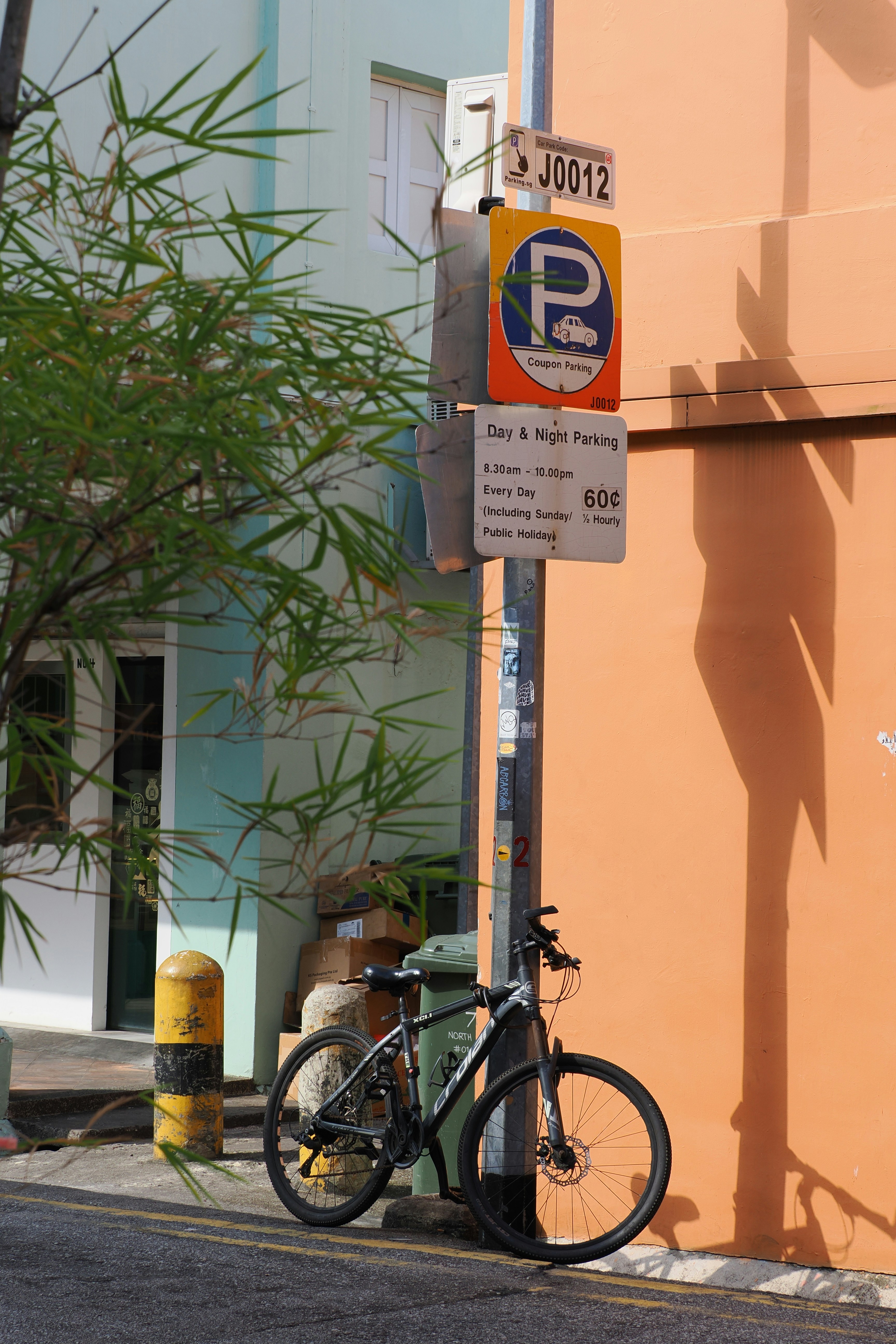 Colorful Street Corner: A Bike Against a Peach Wall and Parking Sign