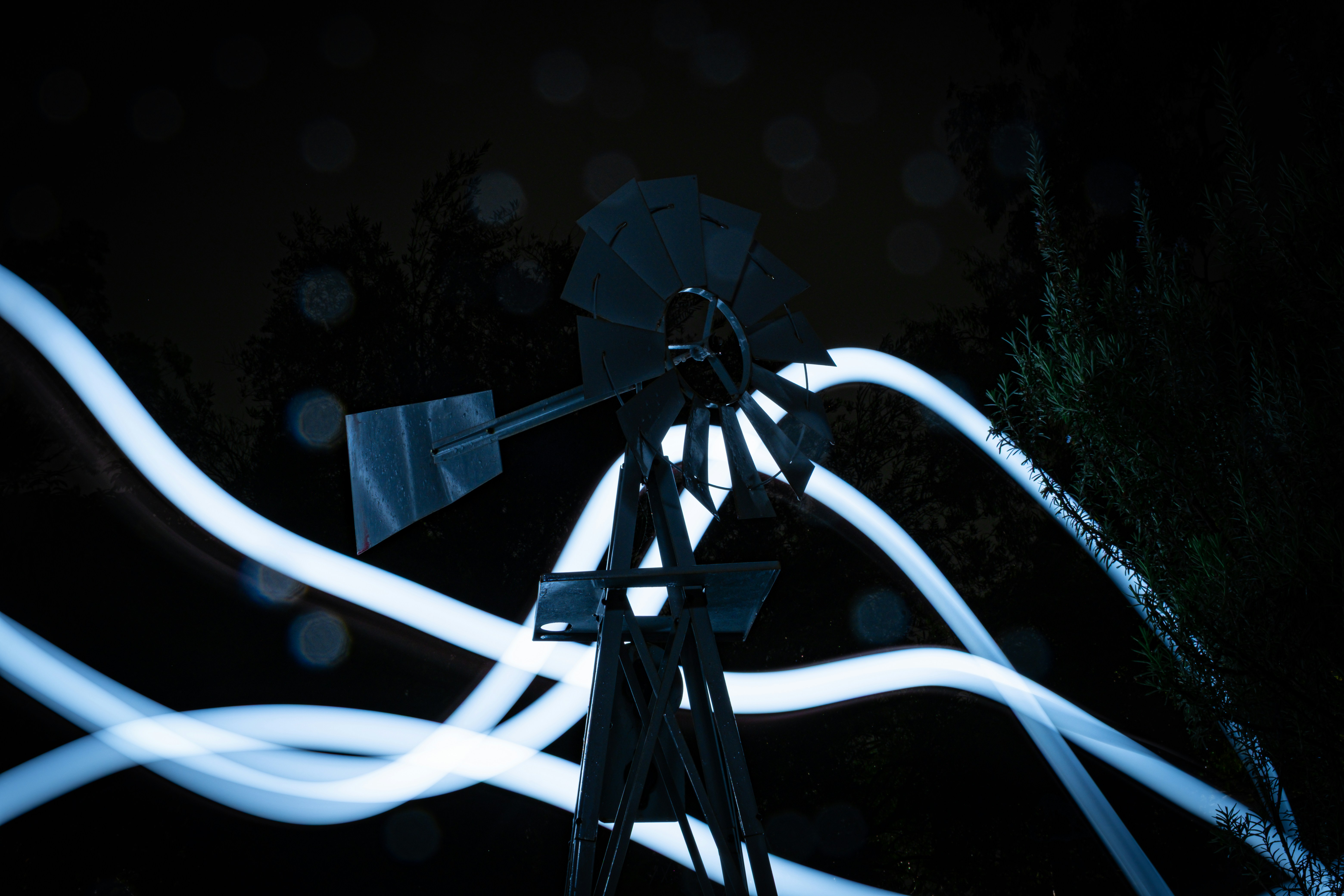 Windmill Rails in Motion: Ghostly Light Trails Across a Night Sky