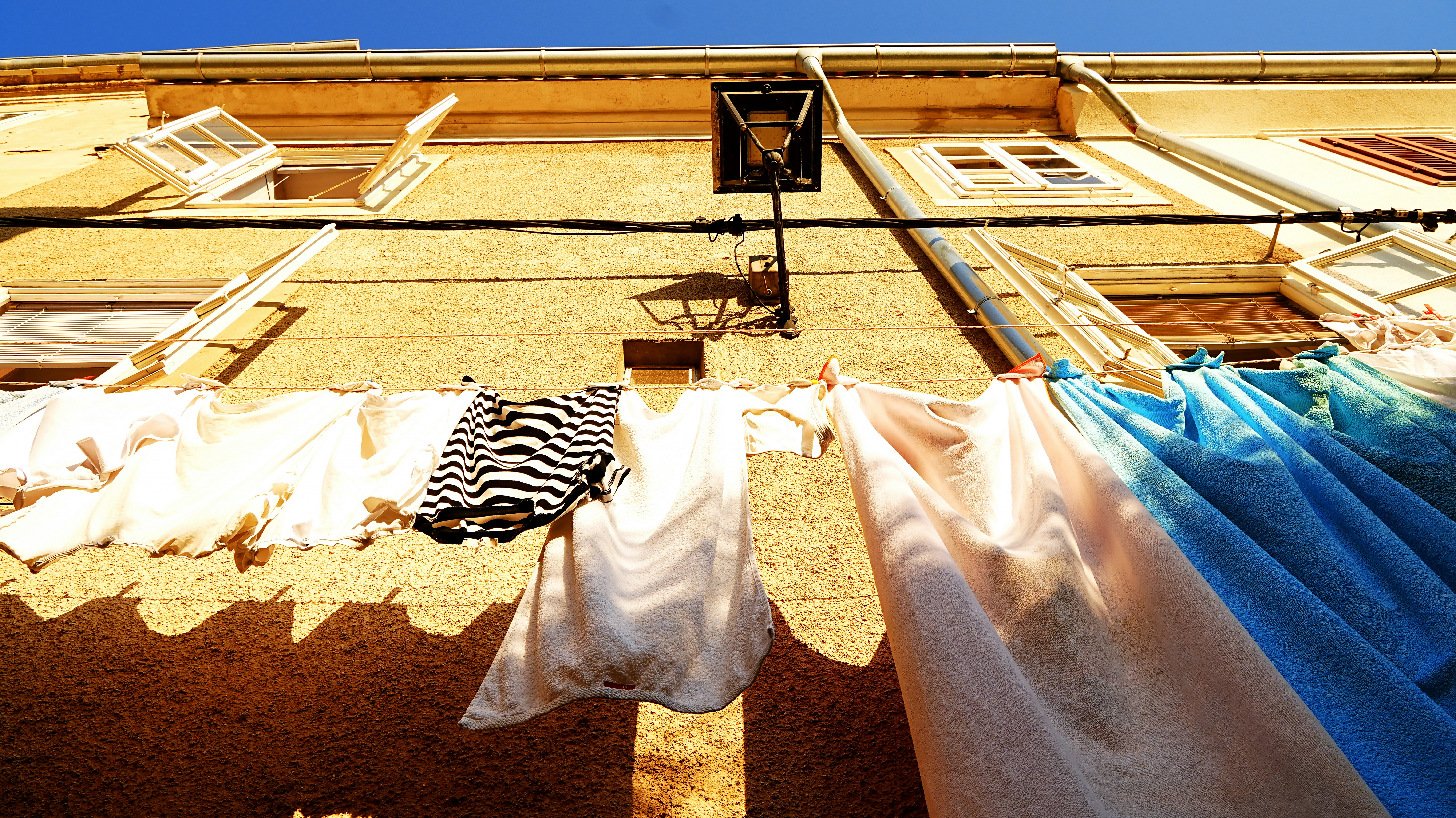 Sunlit Laundry String Across a Warm Facade