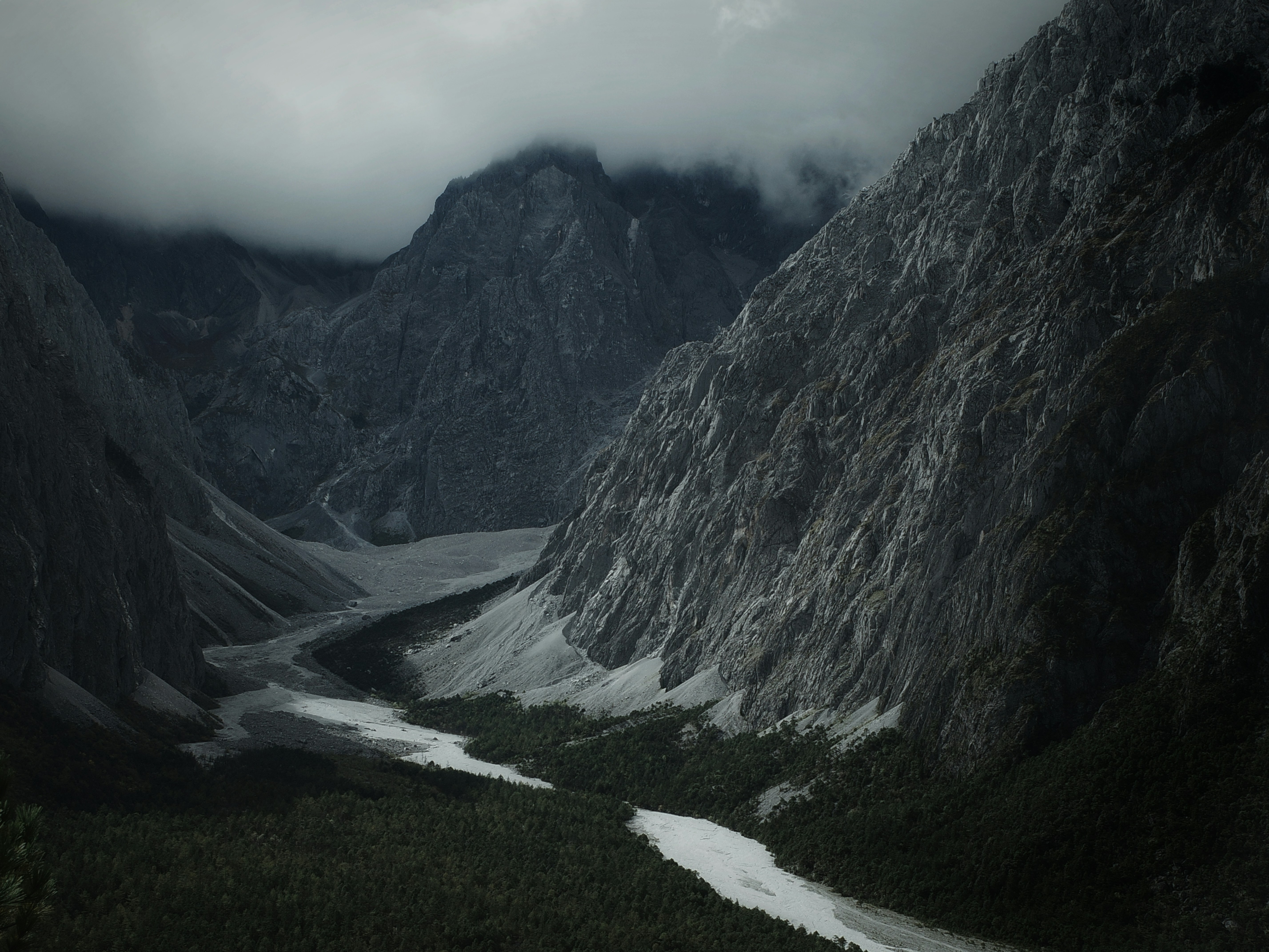 A Narrow Glacier Fold Between Gloomy Peaks