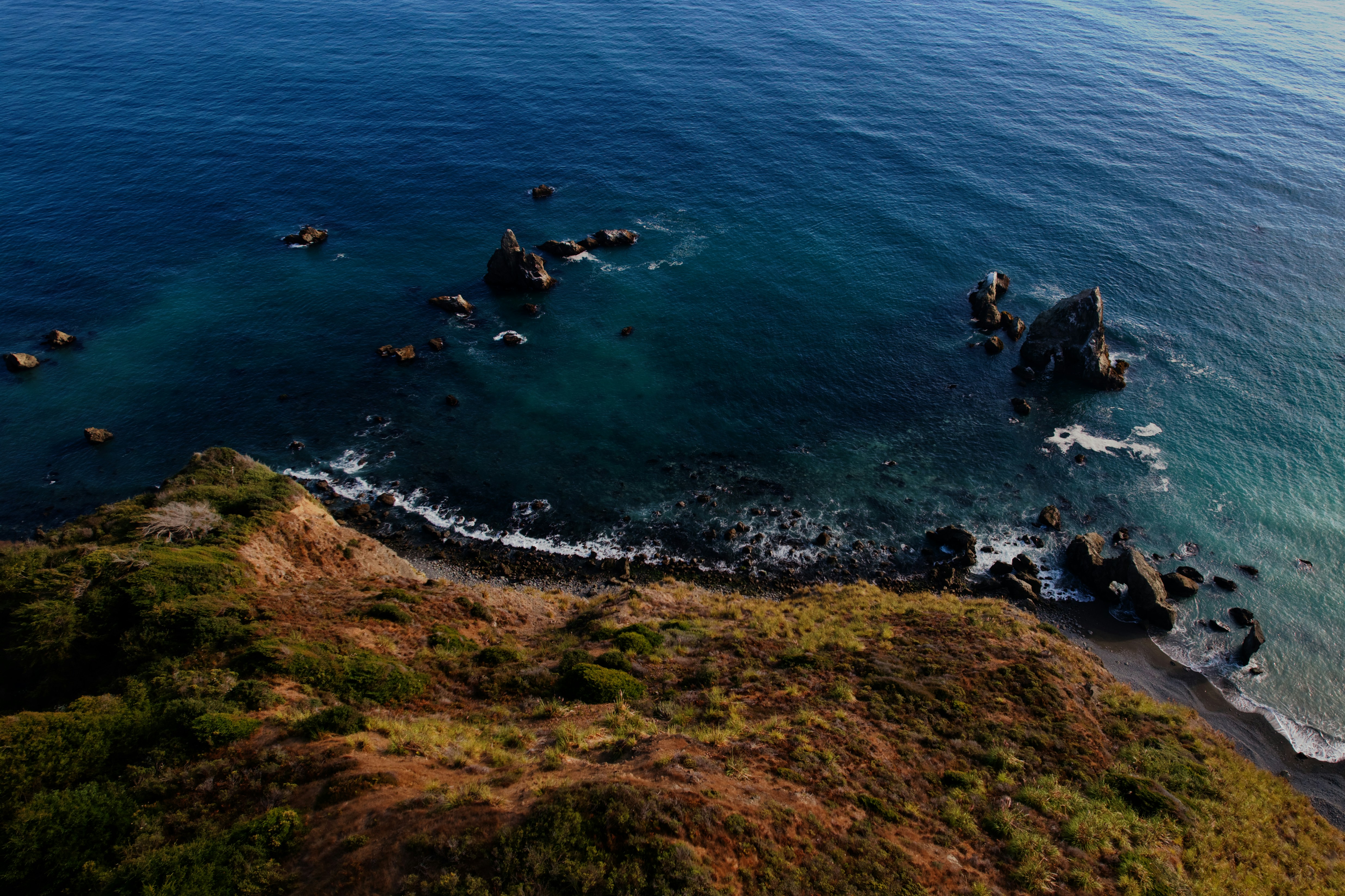 Cliffside Coastline: Aerial View with Turquoise Tide and Rugged Rocks