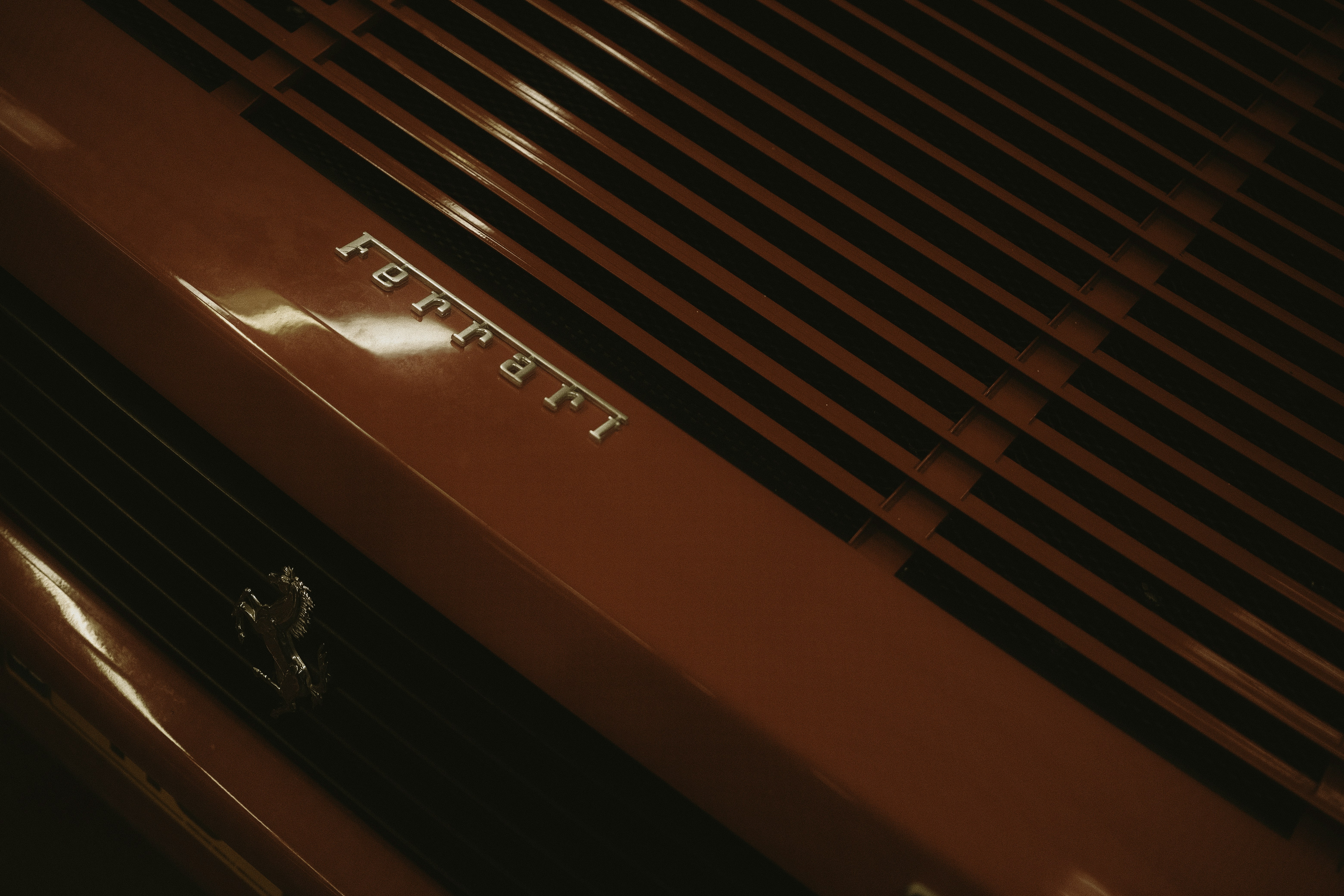 Crimson Grille: Ferrari Emblem Under Red Slats