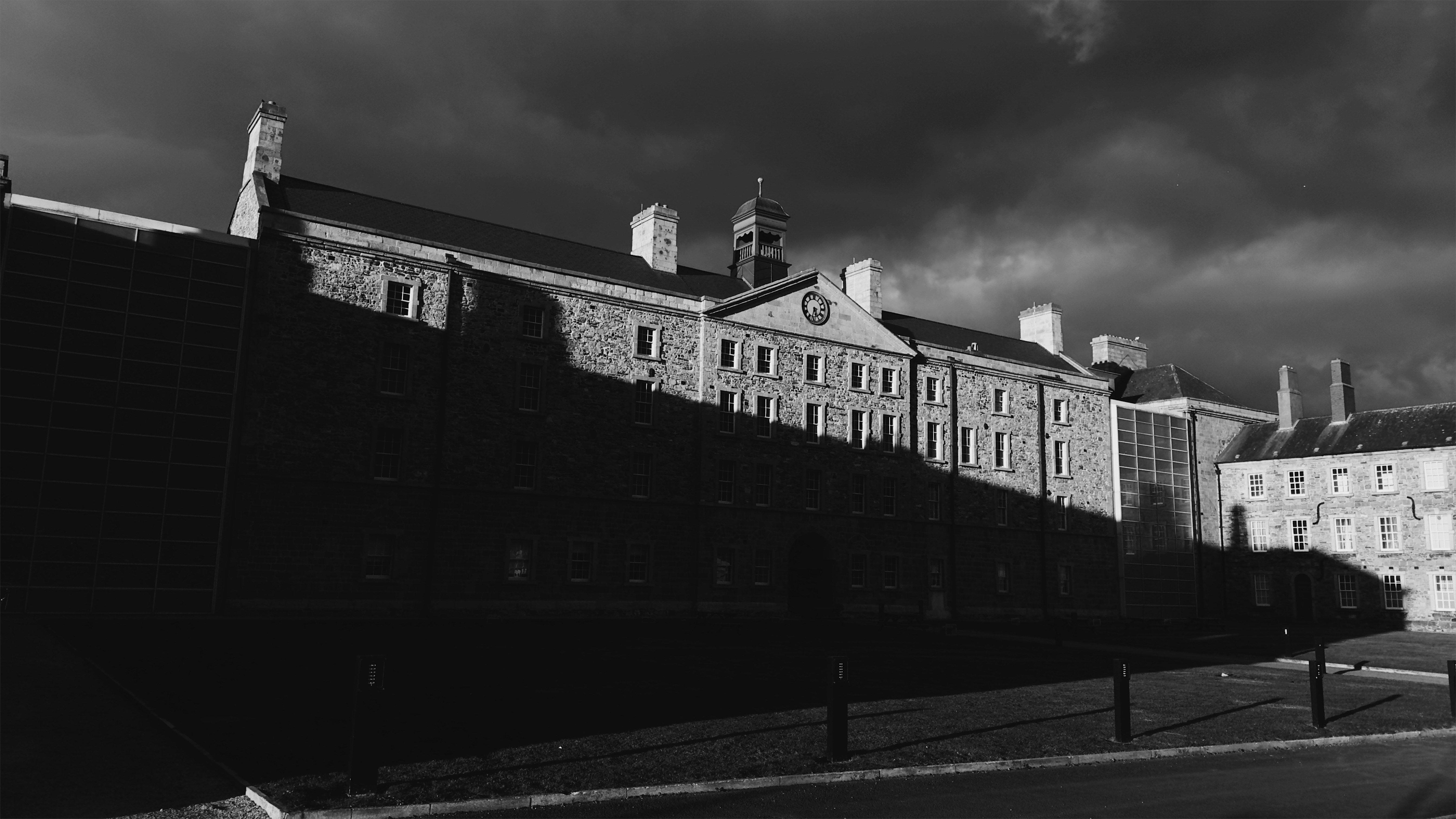 Shadowed Facade: A Monolithic Row of Distant Dwellings Under Dramatic Sky