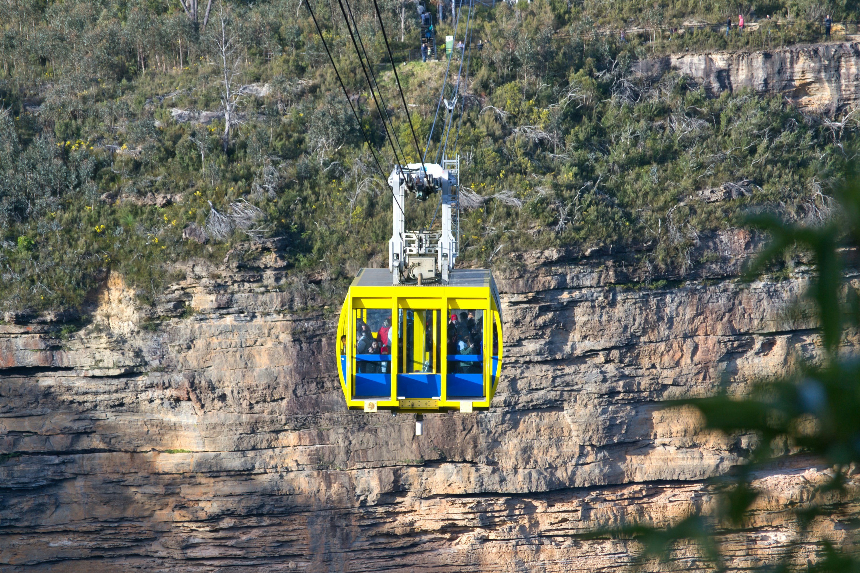 Yellow Cable Car Carves a Sky-Bridge Over Carved Cliffs