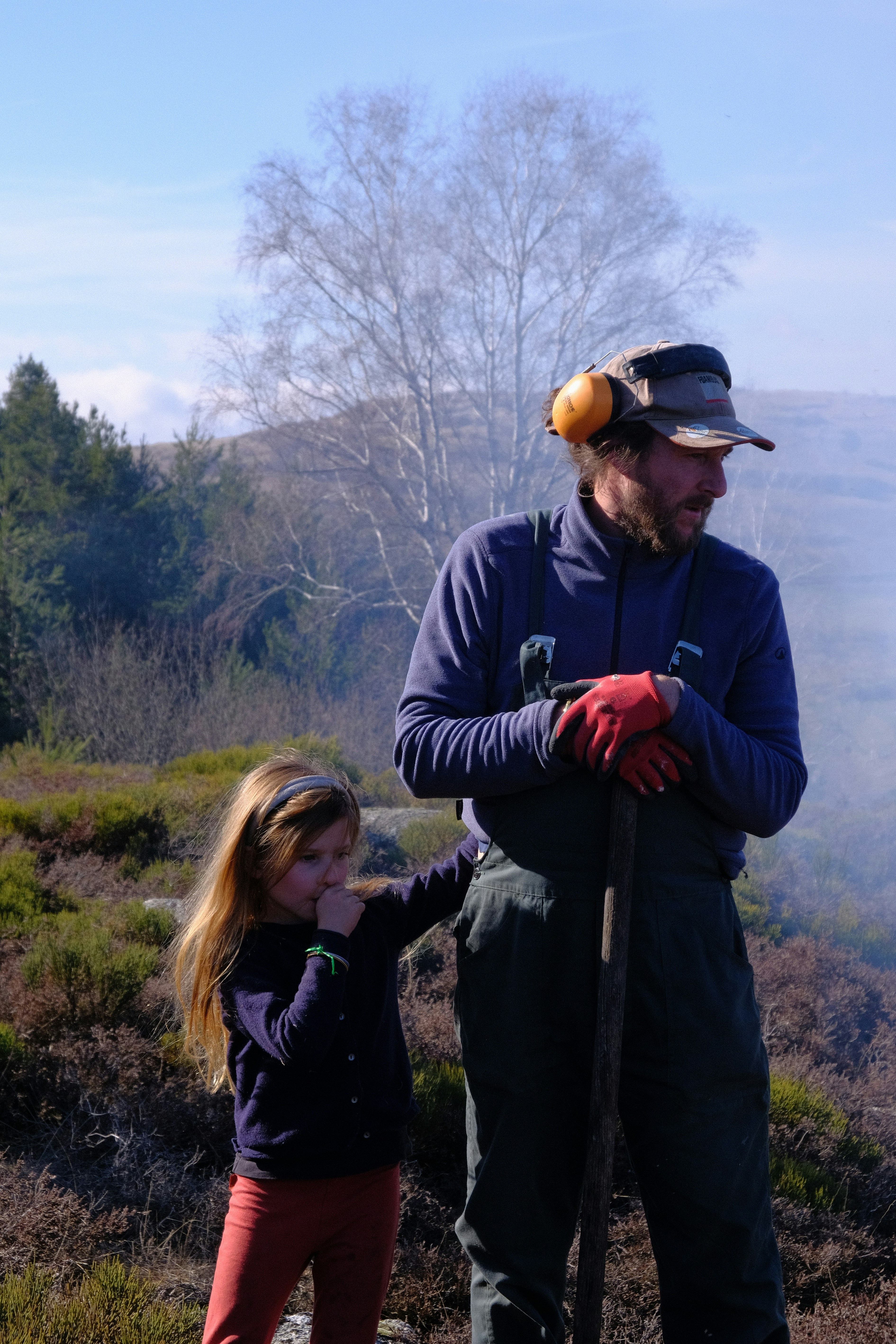 Handshake of Wind and Wood: A Gardener and Child Amid Charred Hills