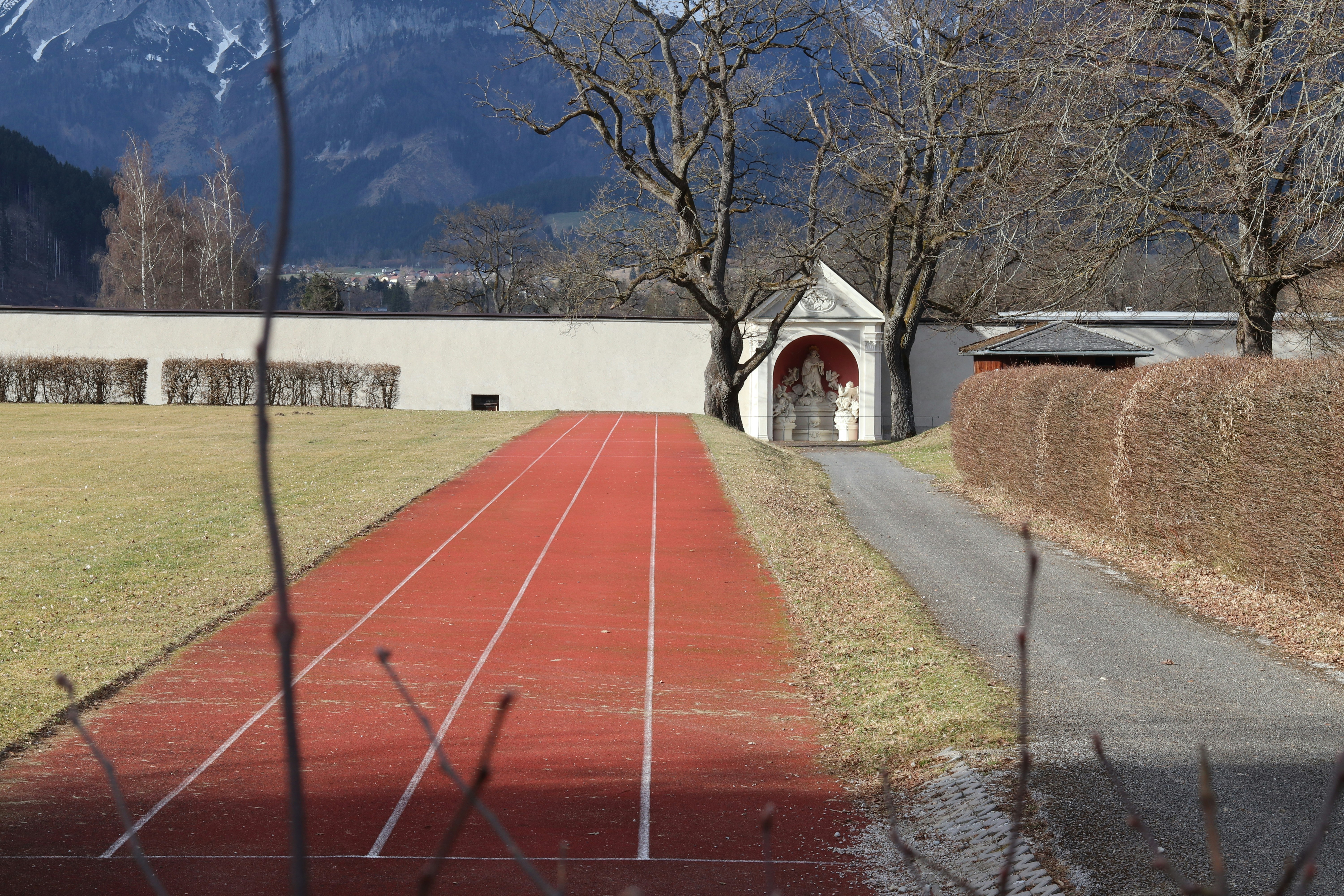 Red Running Lane Leading to a Hidden Arch