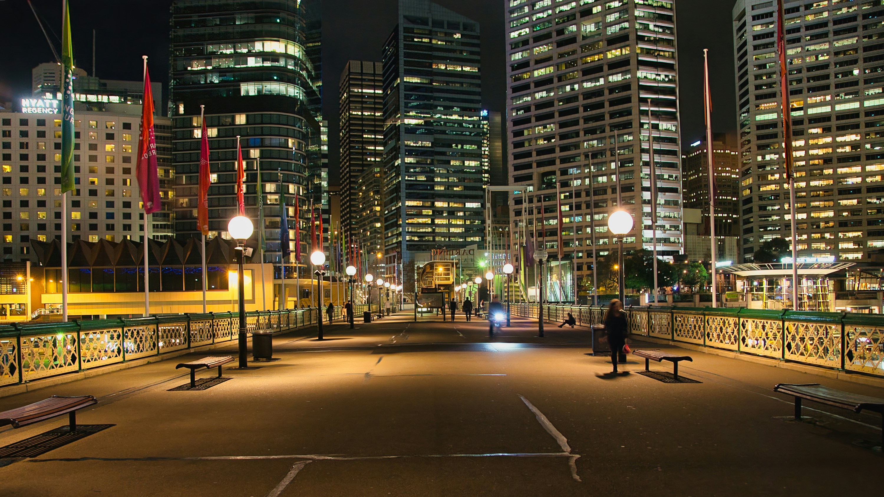 Nighttime Dockside Walkway Framed by Skyscrapers and Lanterns