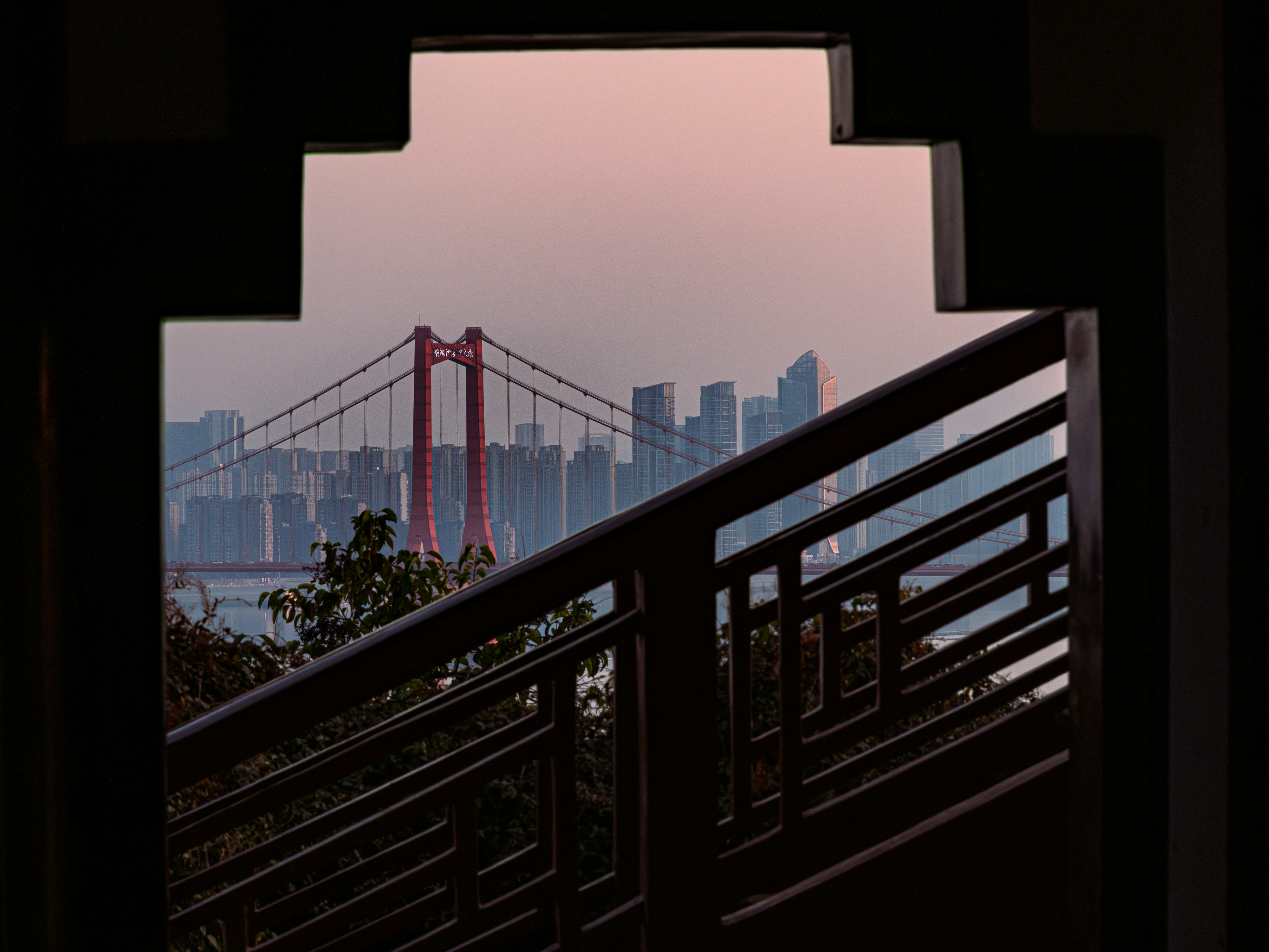 Framed Skyline: A Bridge Weave Through Sunset Silhouettes