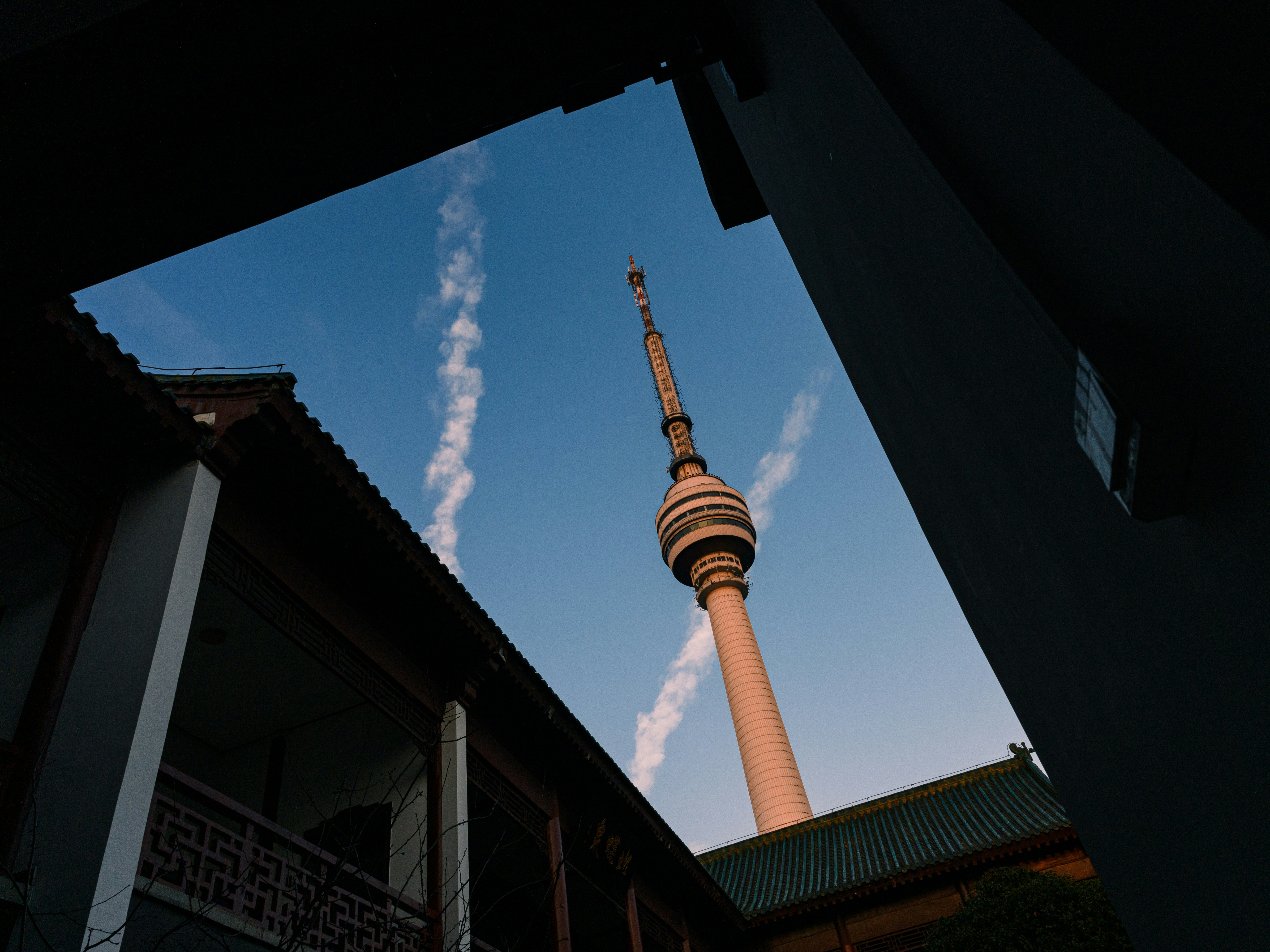 Urban Needle: Framed Skyline Through Historic Eaves