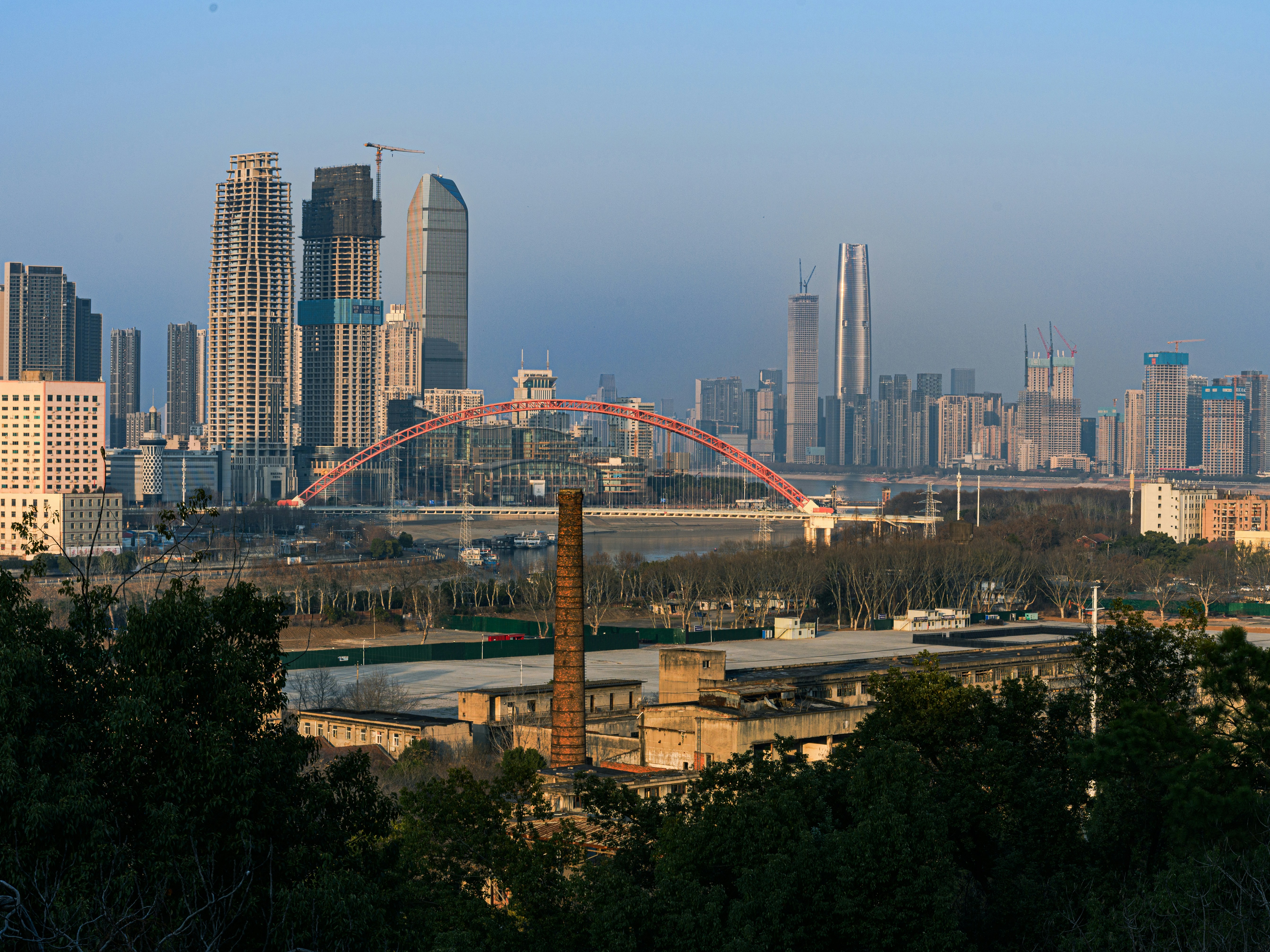 Red Arch Bridge over a Modern Skyline