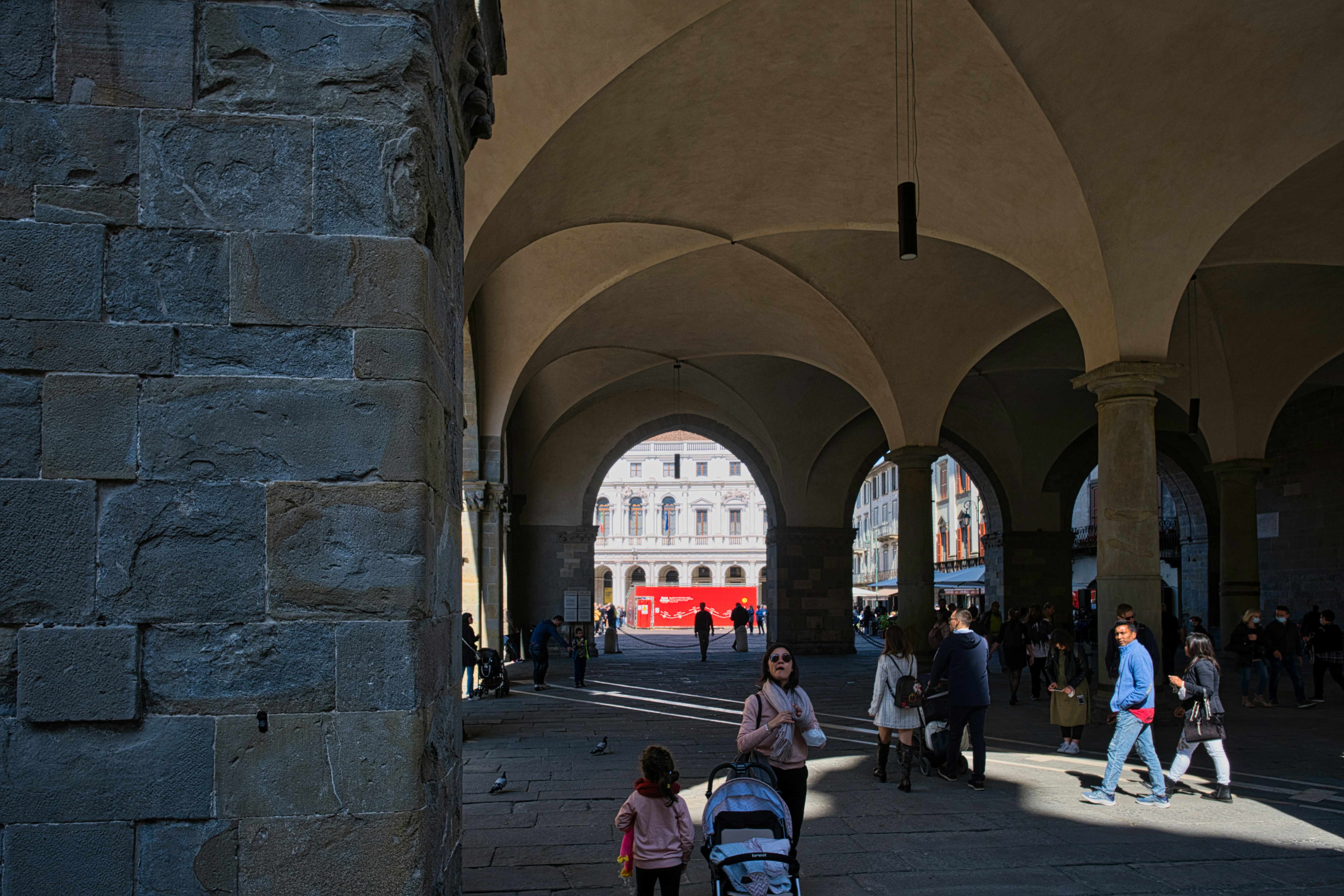  arches of the marketplace: people threading through a sunlit corridor