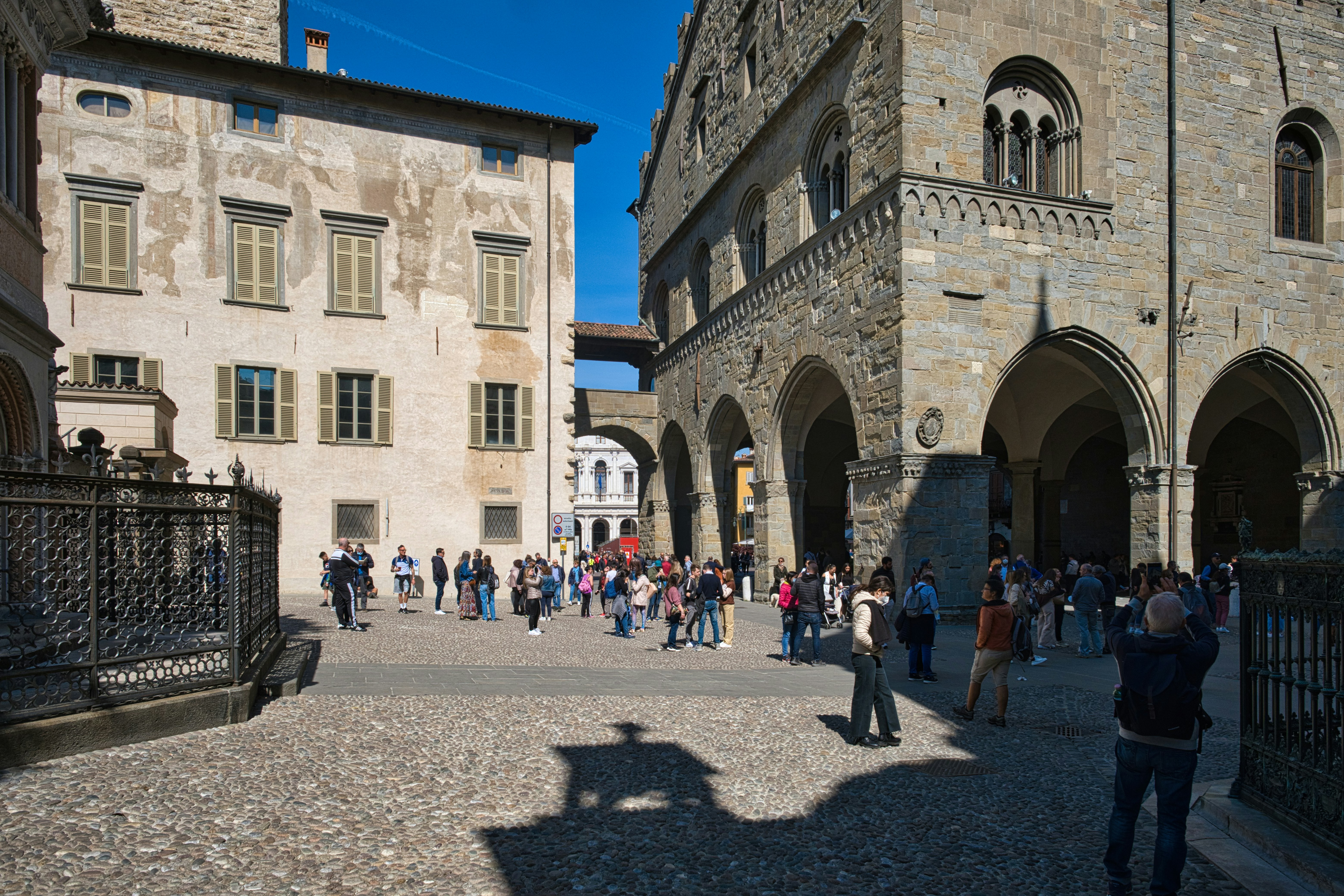 Courtyard Echo: People beneath Ancient Arches