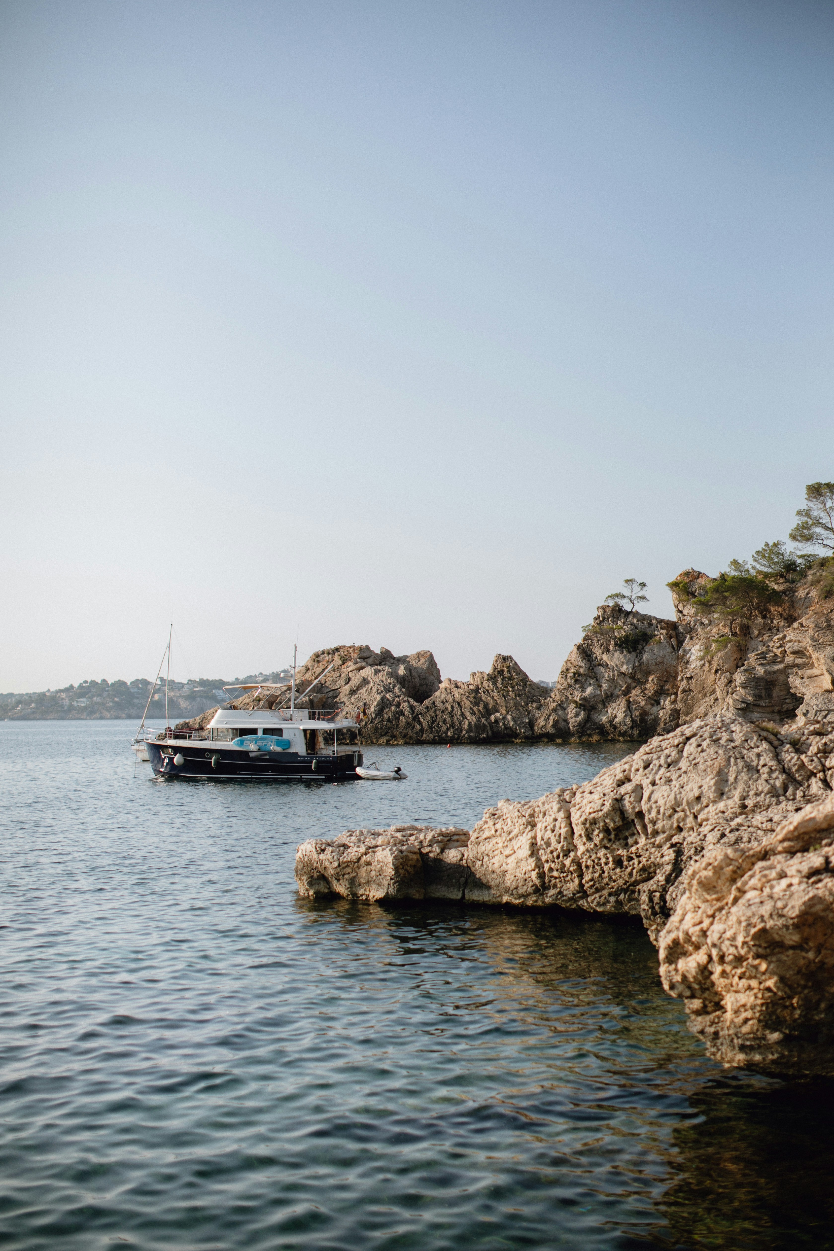 Boat Between Weathered Rocks on a Calm Coastal Tide