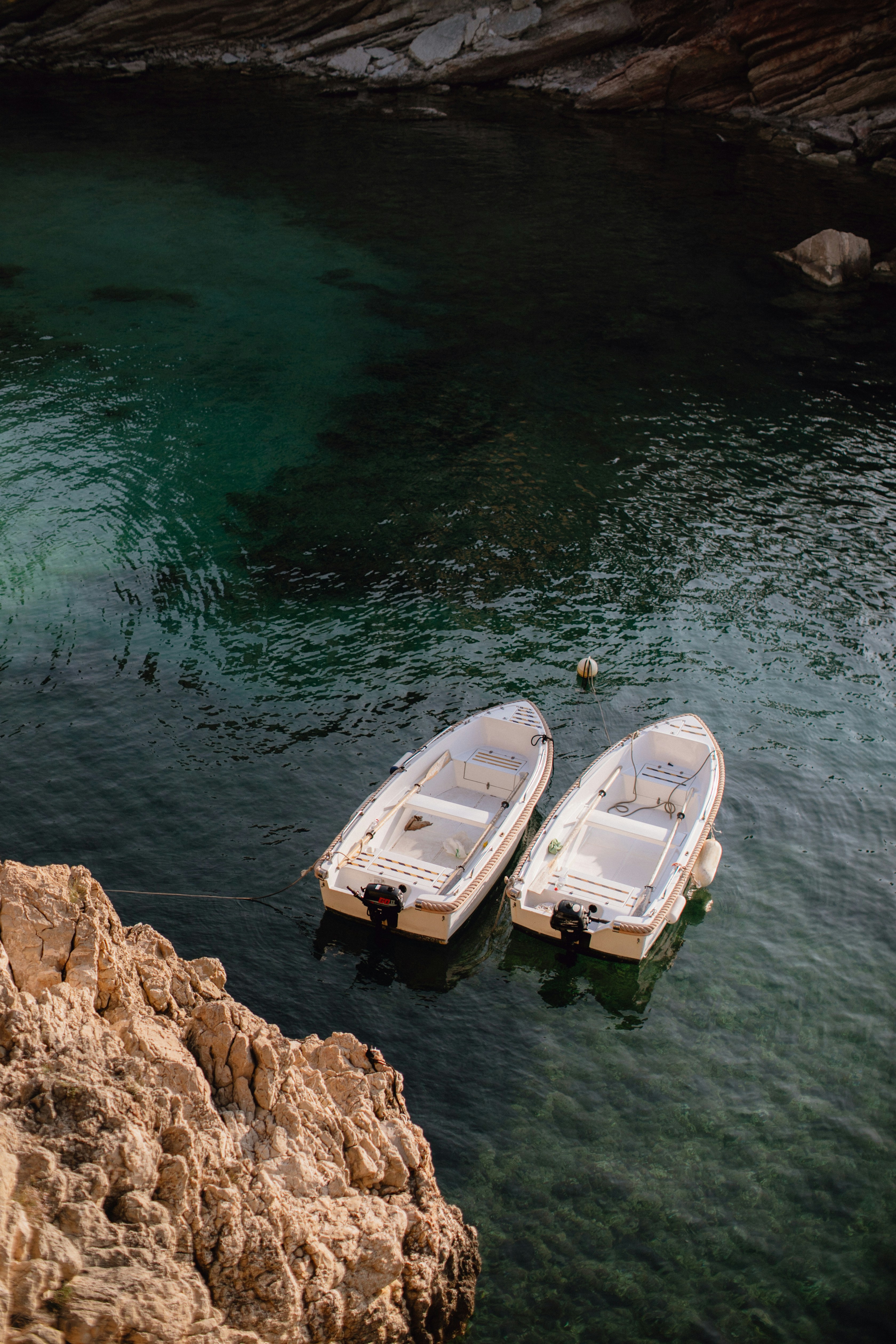 Twin White Boats Adrift in Clear Cove