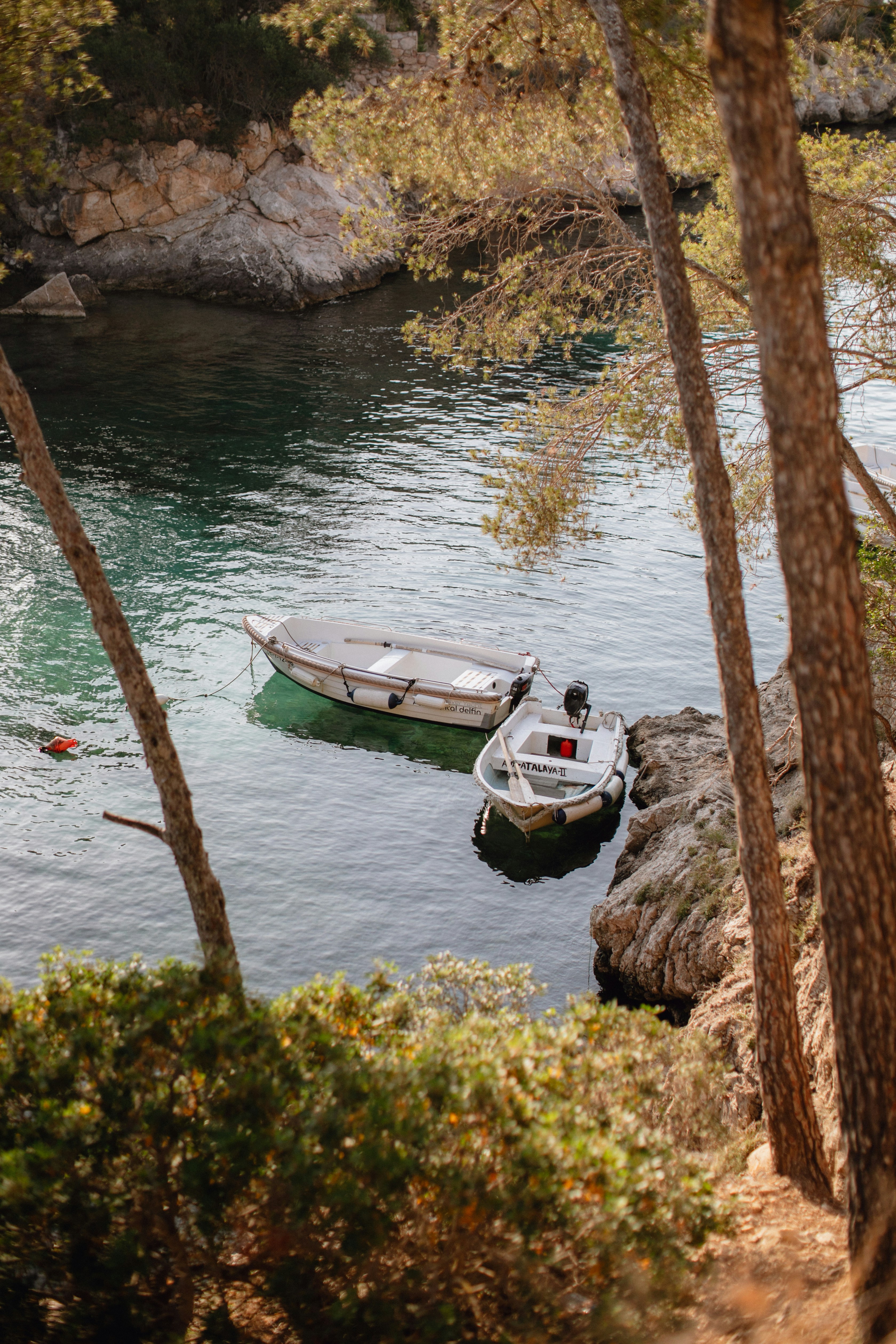 Quiet Cove: Two Boats Rest at the Edge of Emerald Water