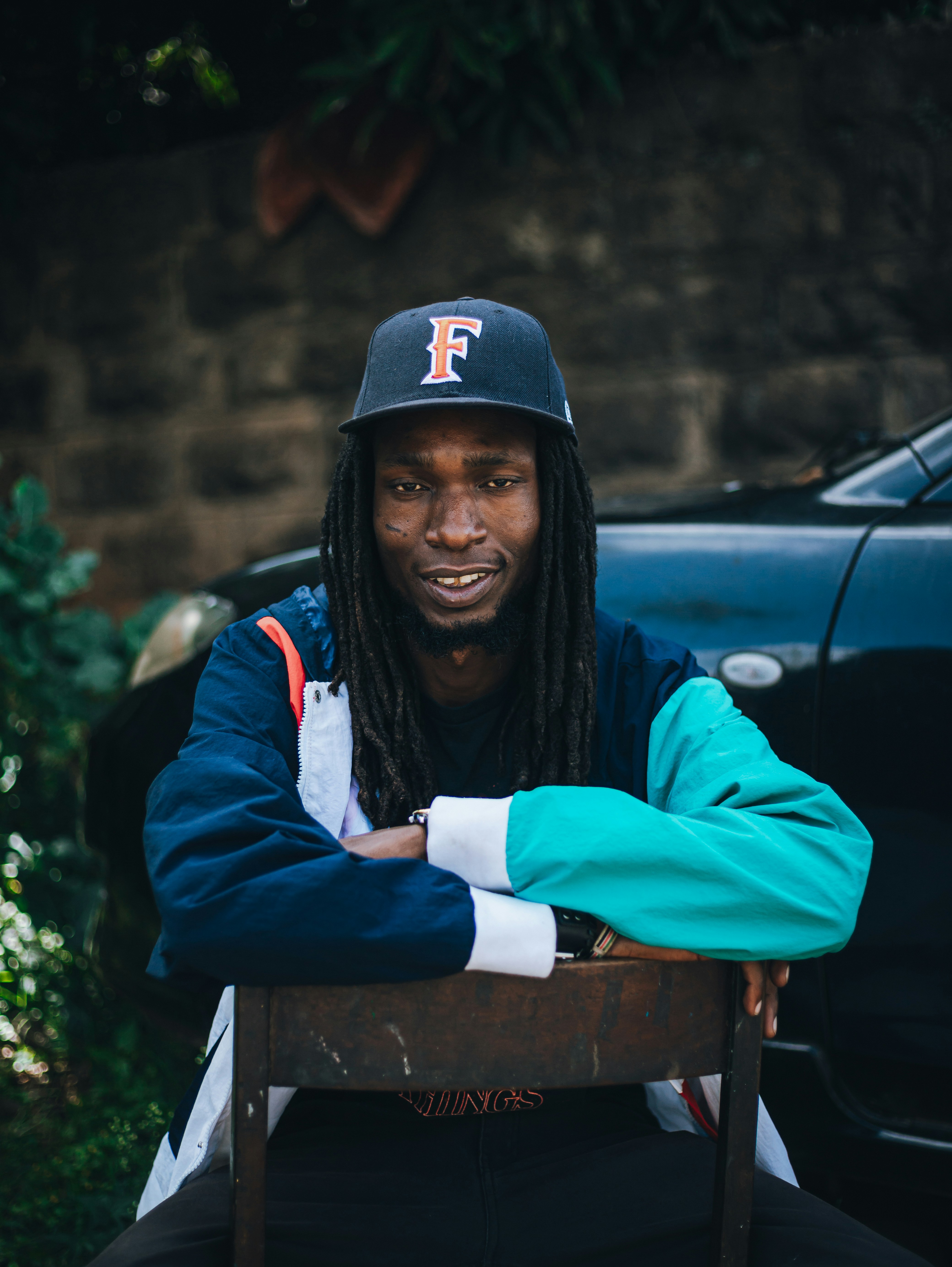 Portrait on a Weathered Set: Calm Confidence Amid Car and Wall