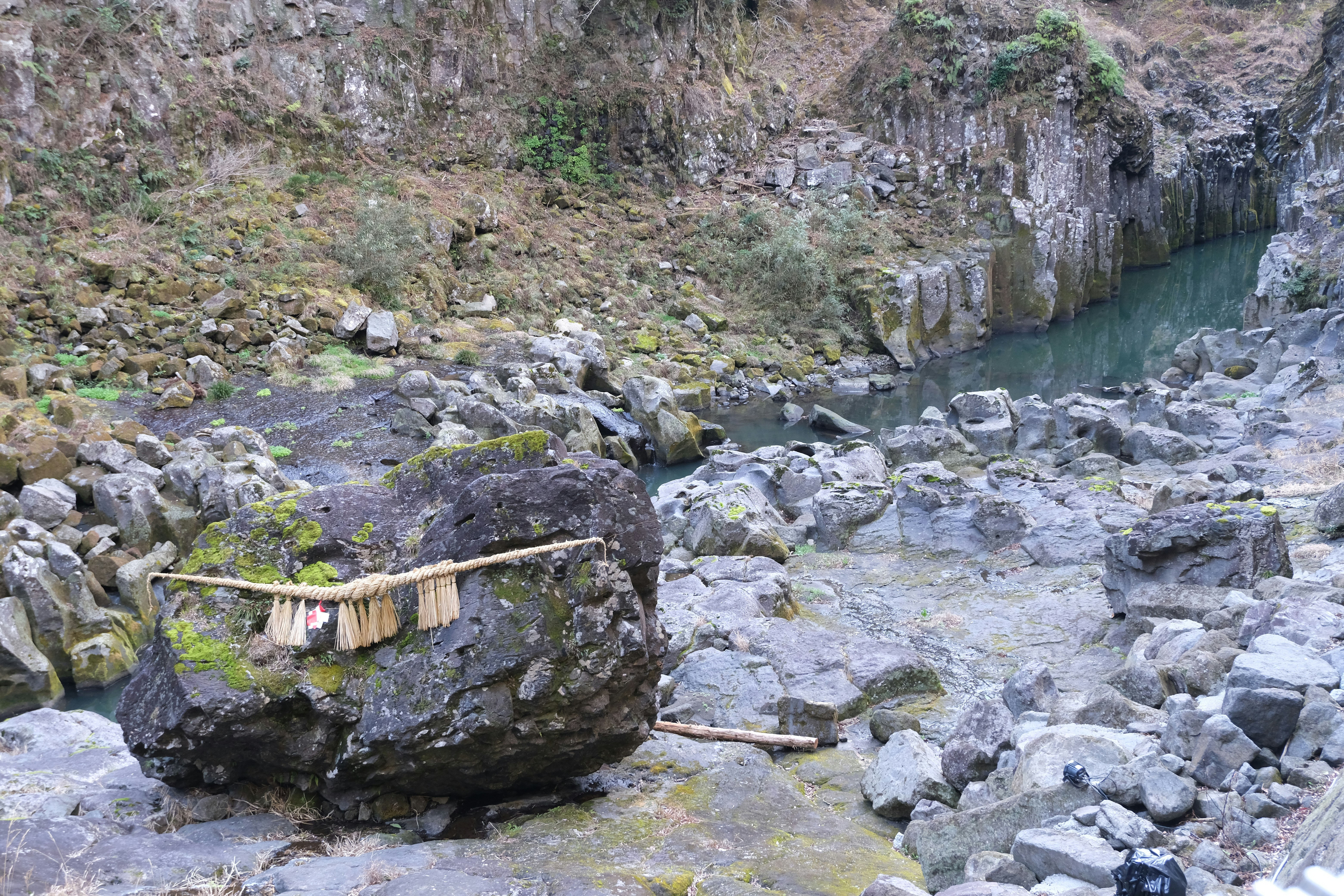 Rugged riverbank with weathered rock and driftwood