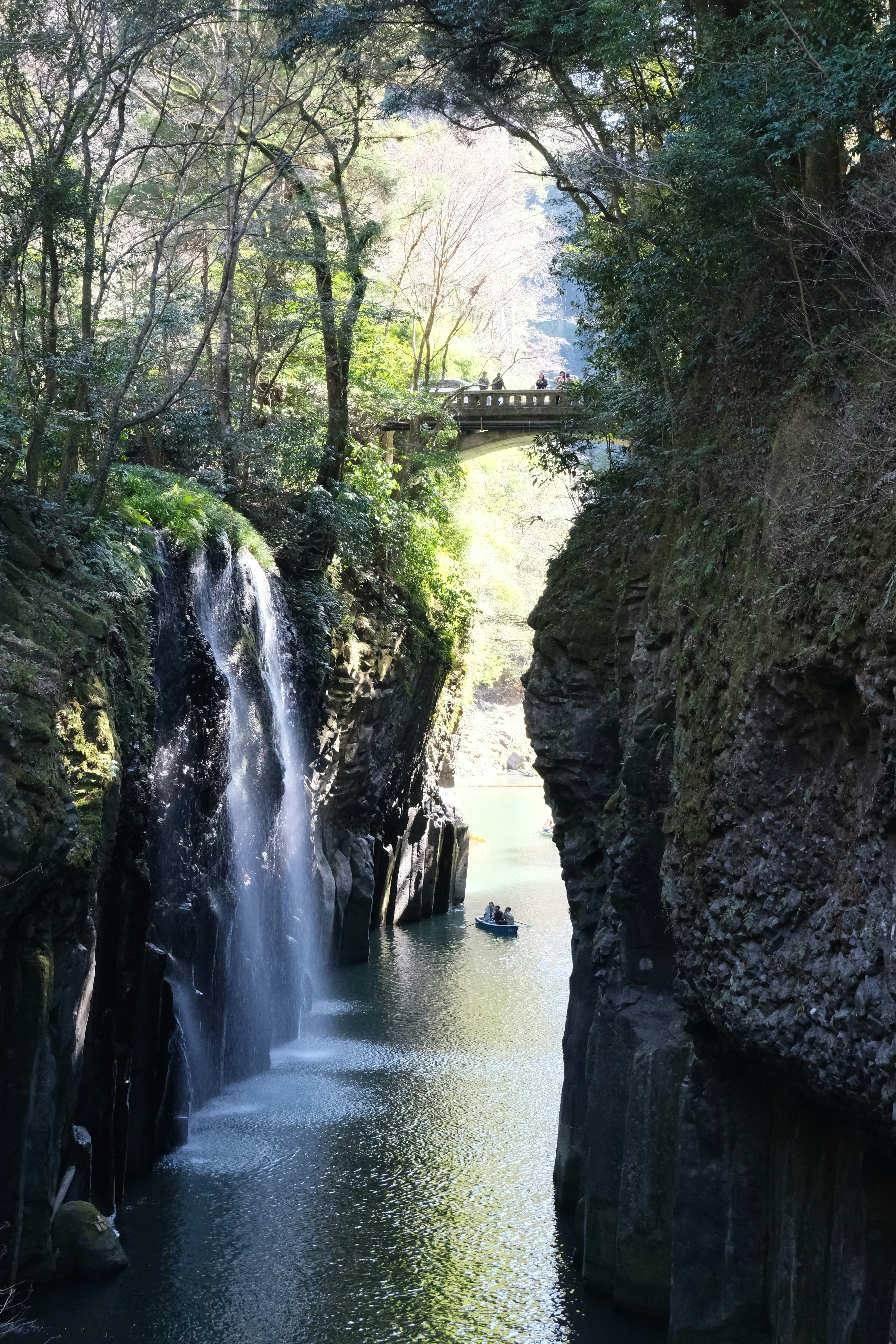 Bridge Over a Sunlit Gorge: A Quiet Boat Passages Through Narrow Canyon