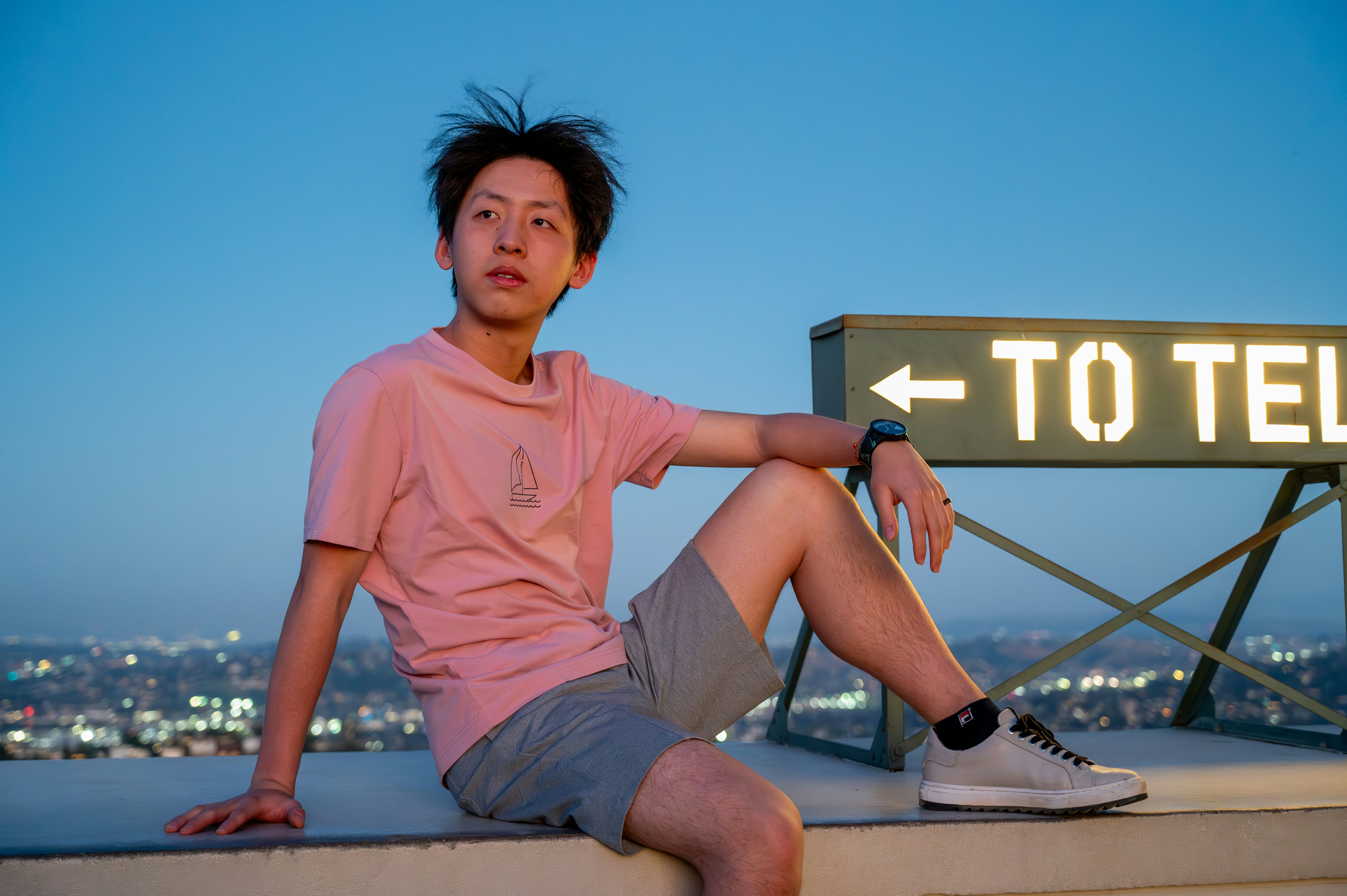 Rooftop Gaze: A Quiet Moment by the Neon Sign