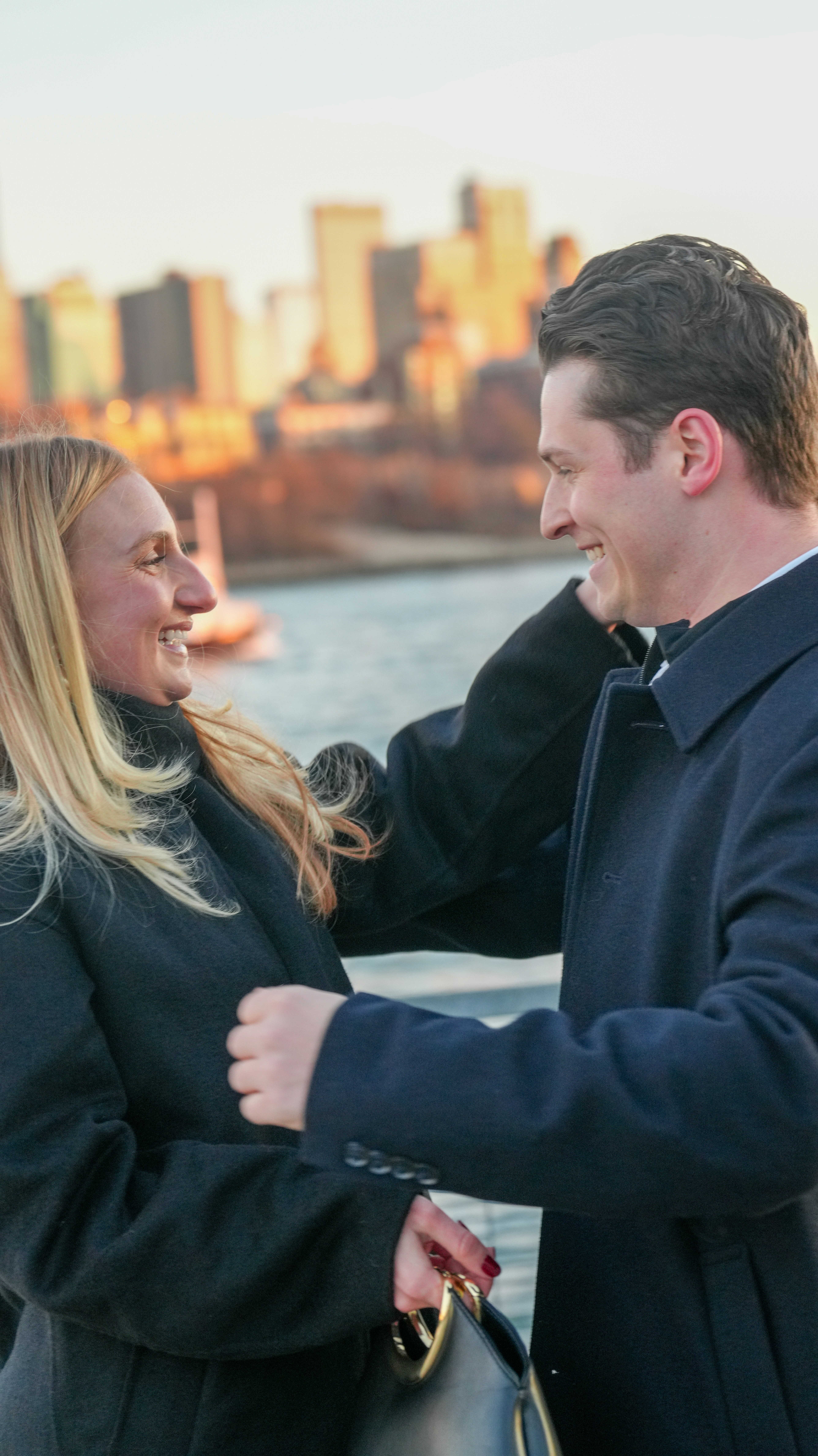 Joyful embrace on the waterfront as city lights glow