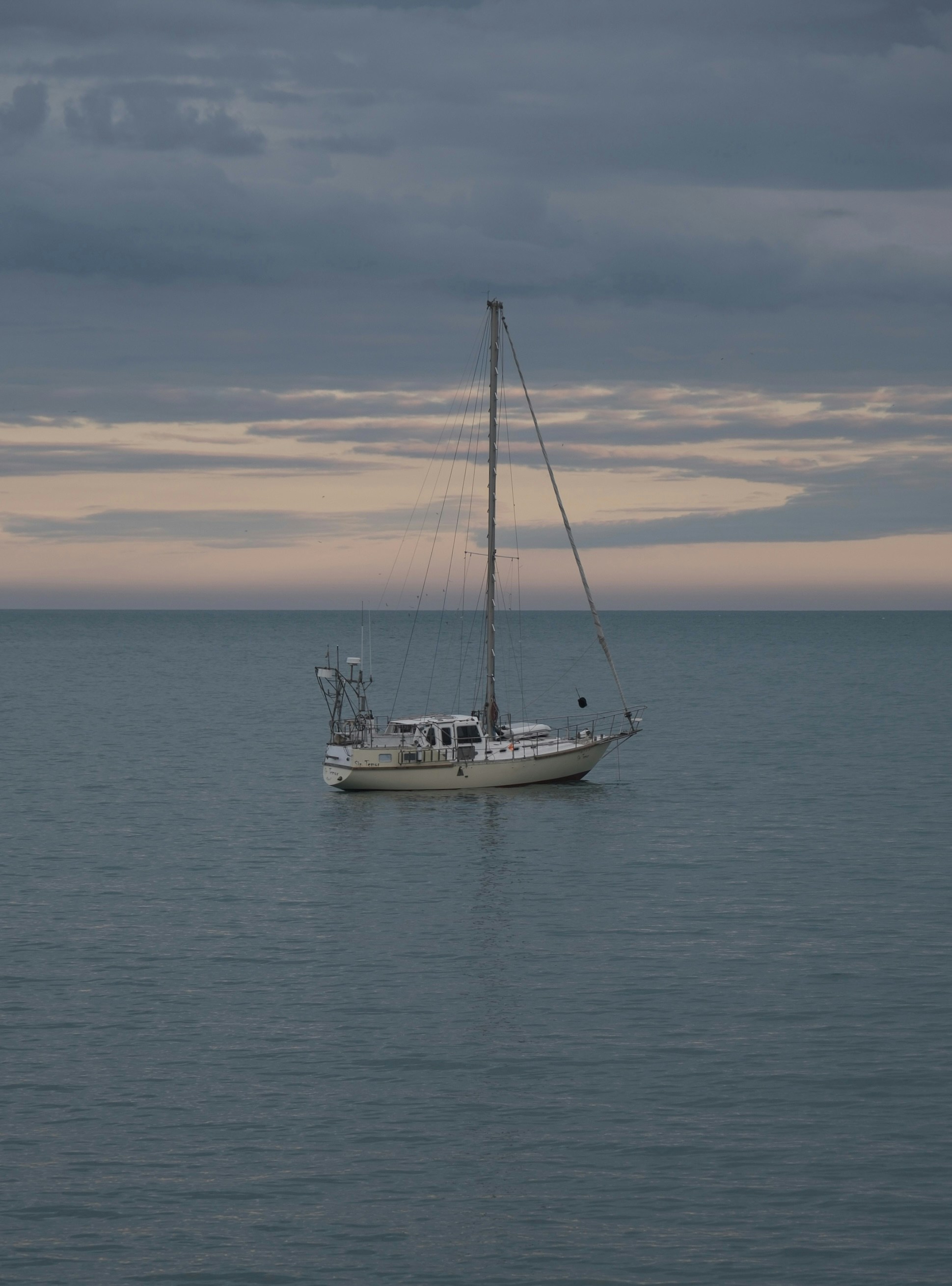 Sailboat in quiet sea at sunset