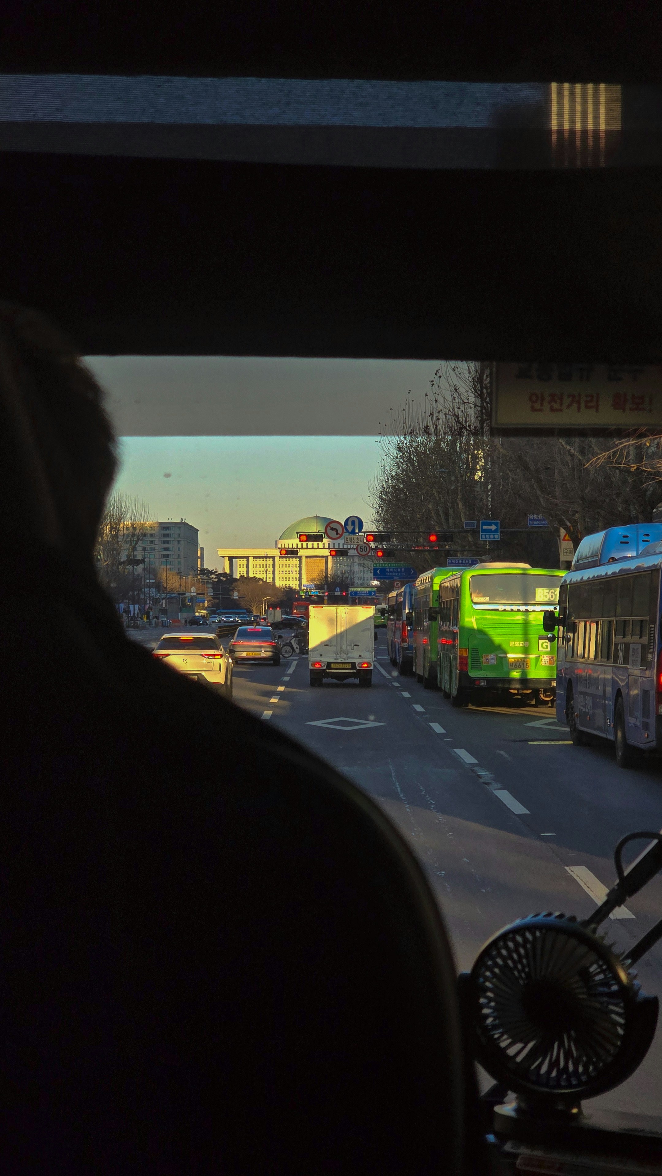 Midday Bus Road: Front Cab Perspective Through a Bus Window