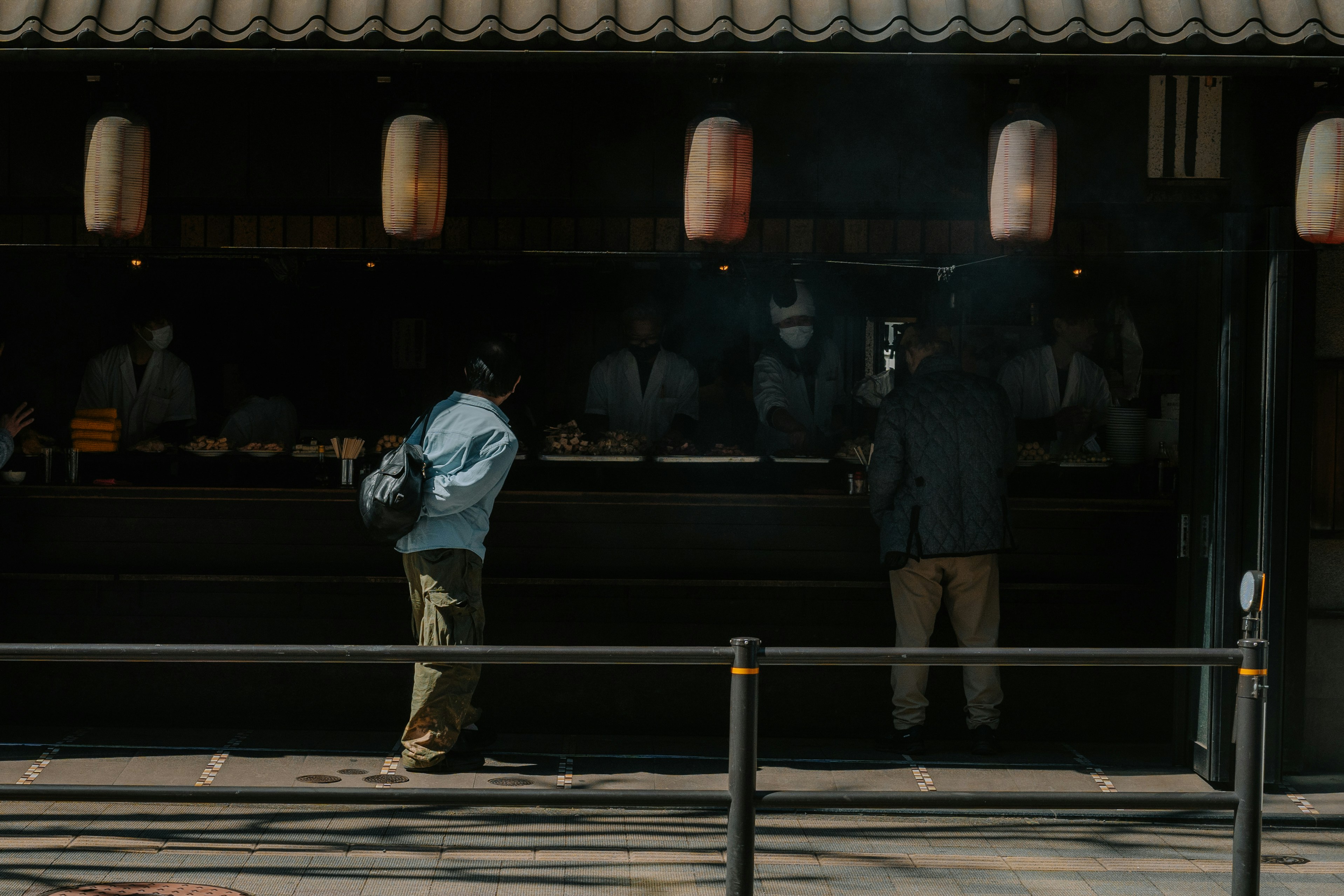 Quiet Street Sushi Window: A Shopper Pauses by the Night Market