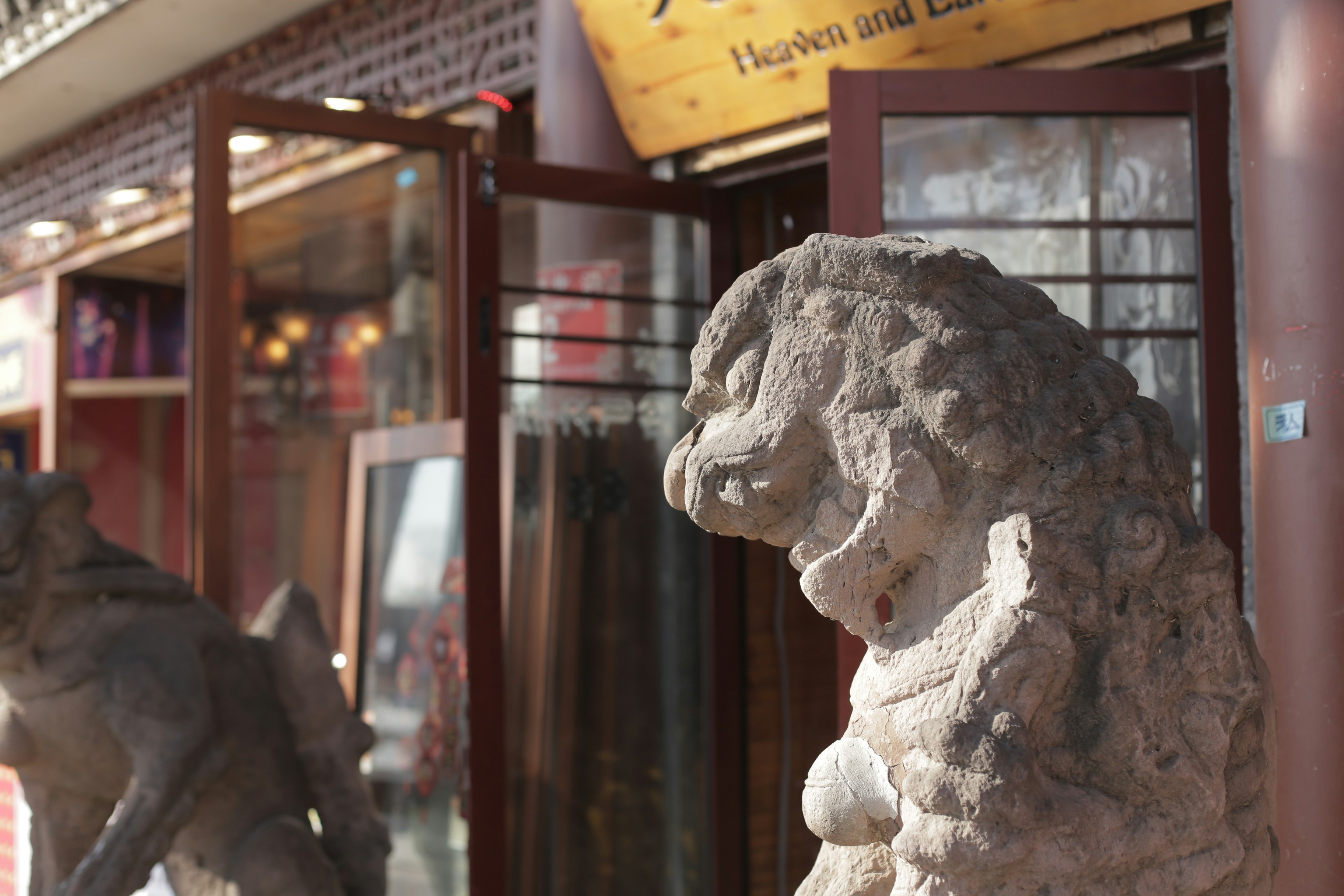 Stone Guardian at the Threshold of a Lantern-lit Shop