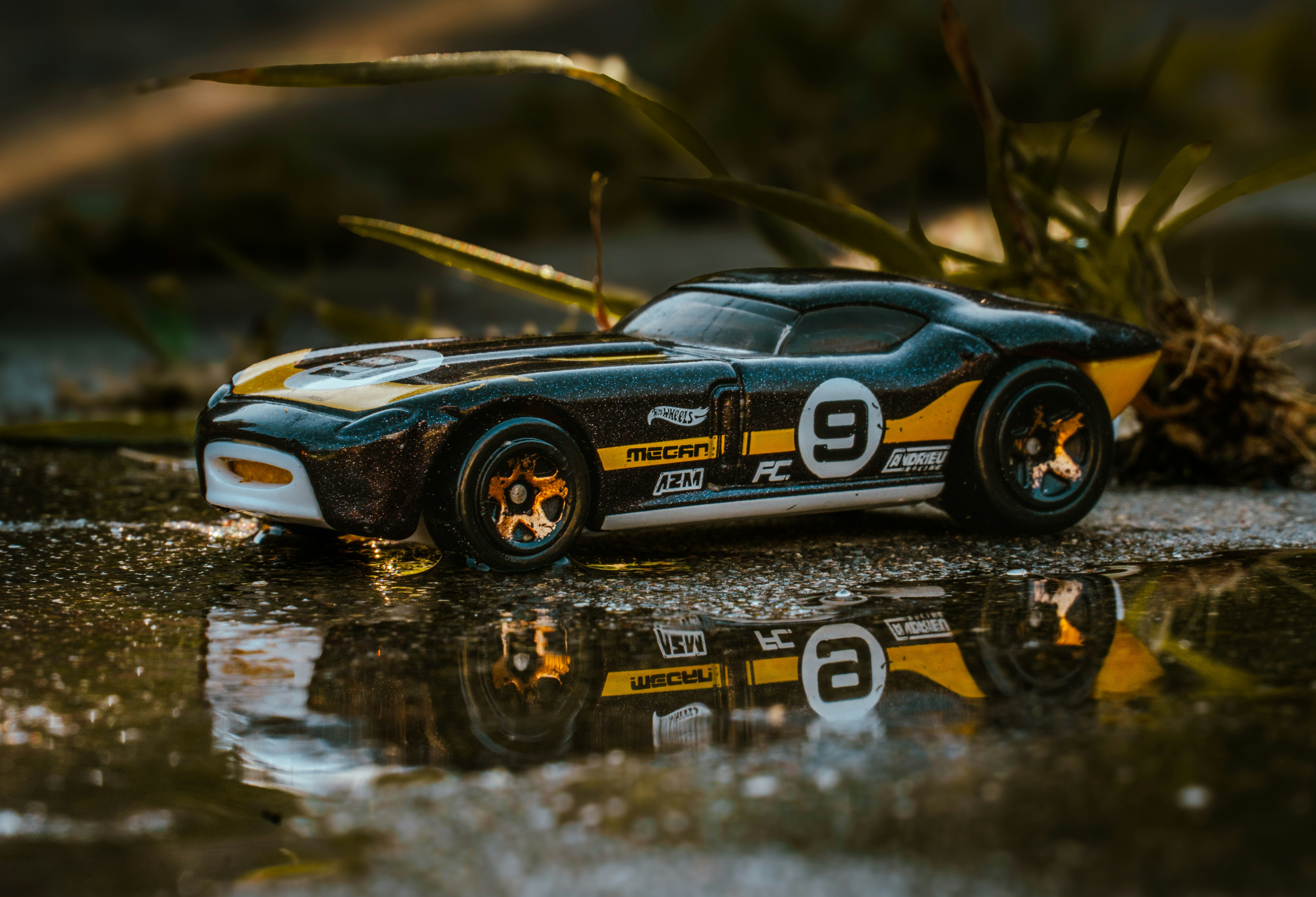 Mini Racer, Big Reflections: A Weathered Toy Car on a Puddle Stage