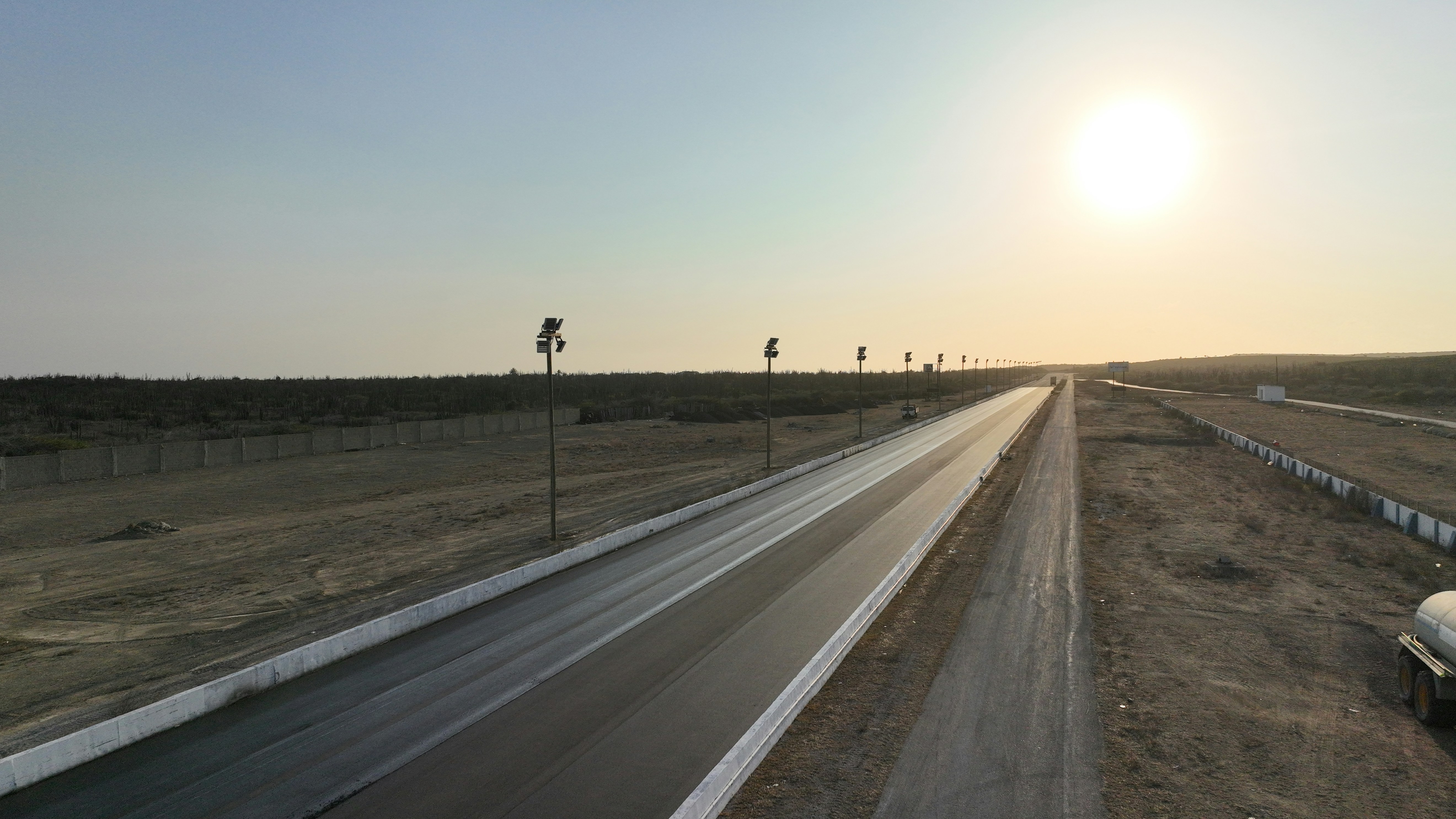 Sunlit straight: endless road under a calm desert sky
