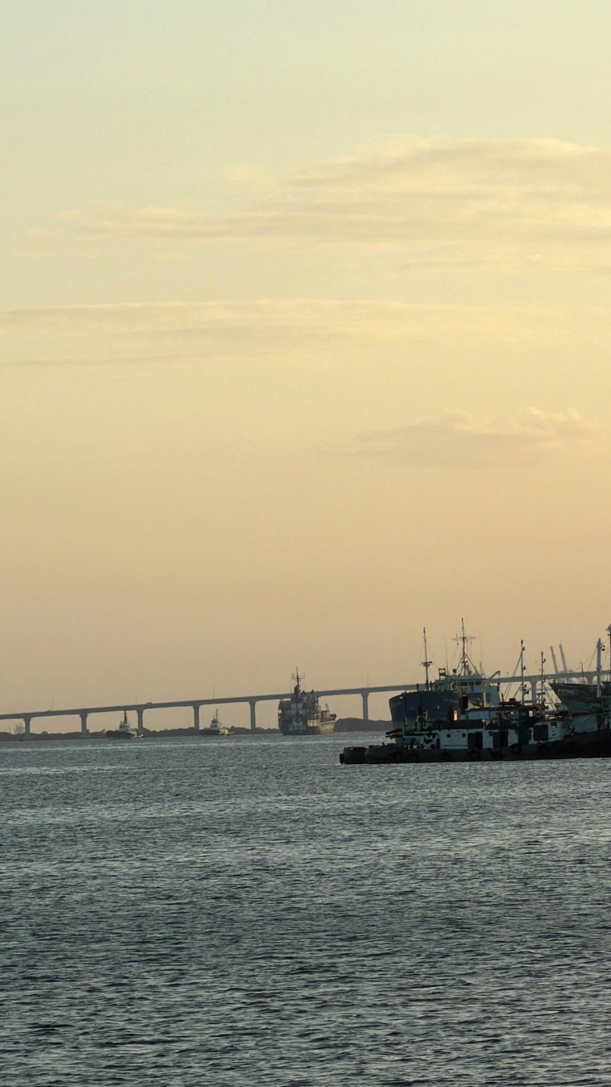 Evening Anchorage: Boats at Dusk Beneath a Pier-Linked Horizon