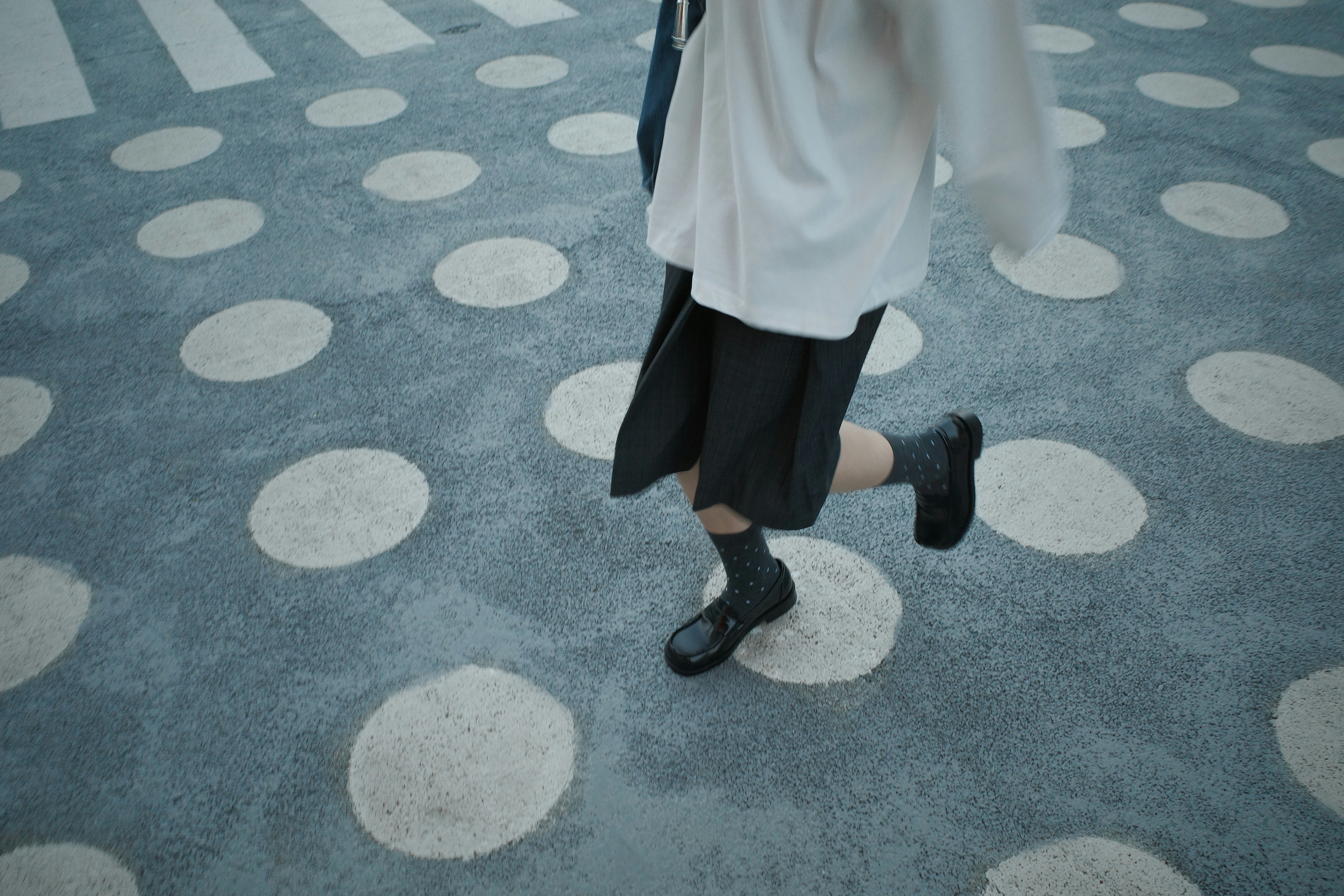 Footsteps Across Dotted Light: A Quiet Walk in a Painted Playground