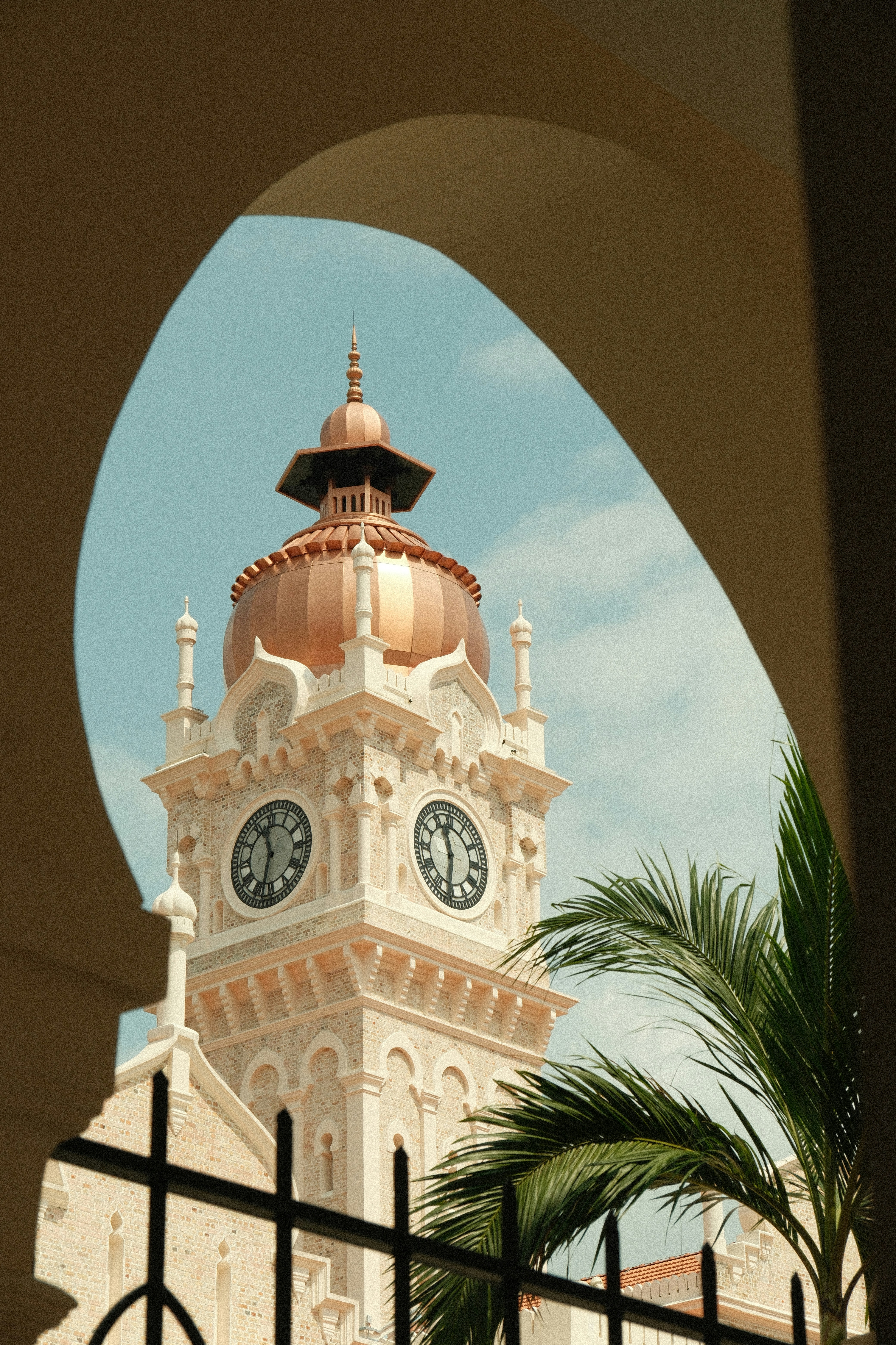 Crescent Clock Tower Framed by Archway and Palm