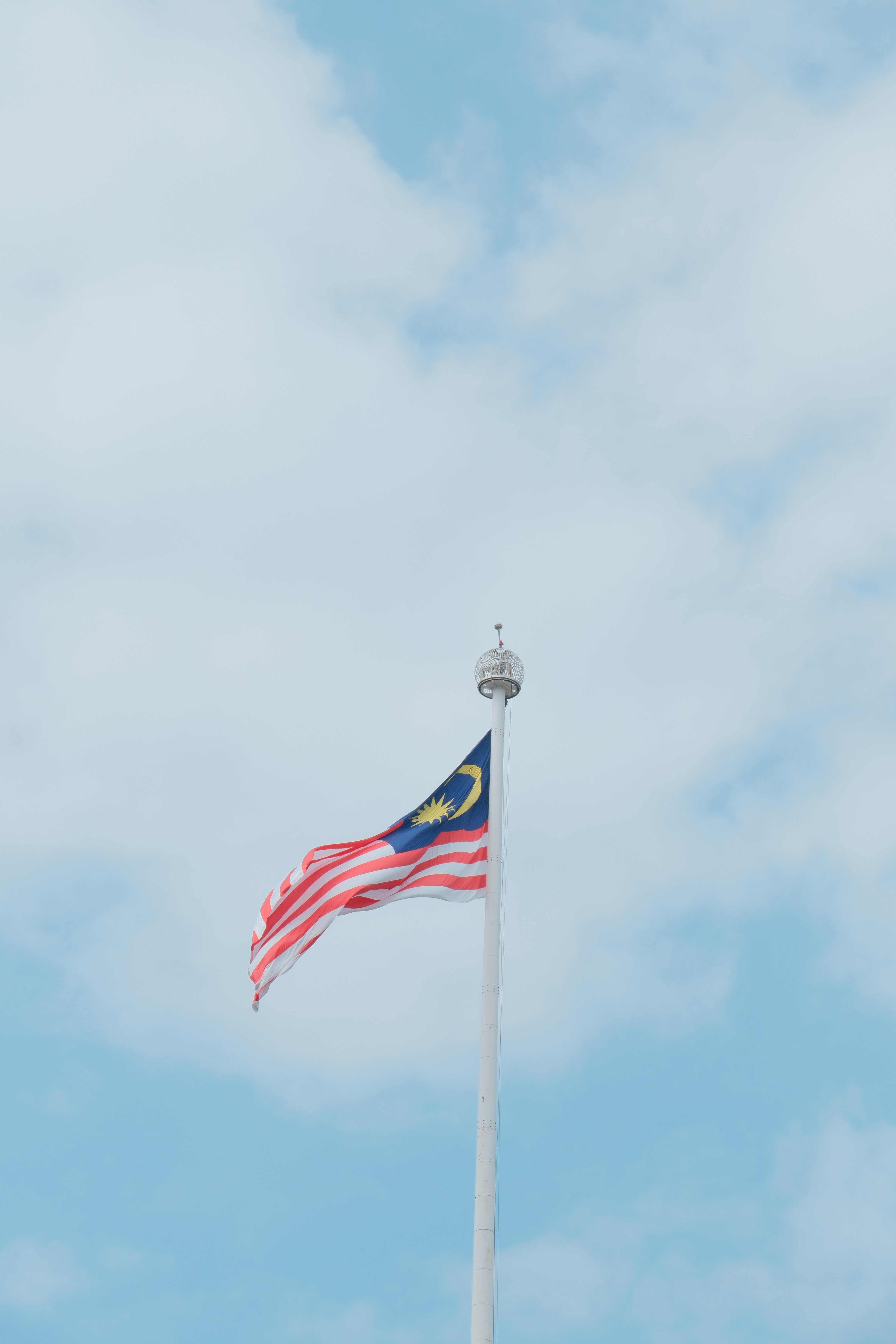 Flag against a Pale Sky: Malaysia’s Emblem in Flight