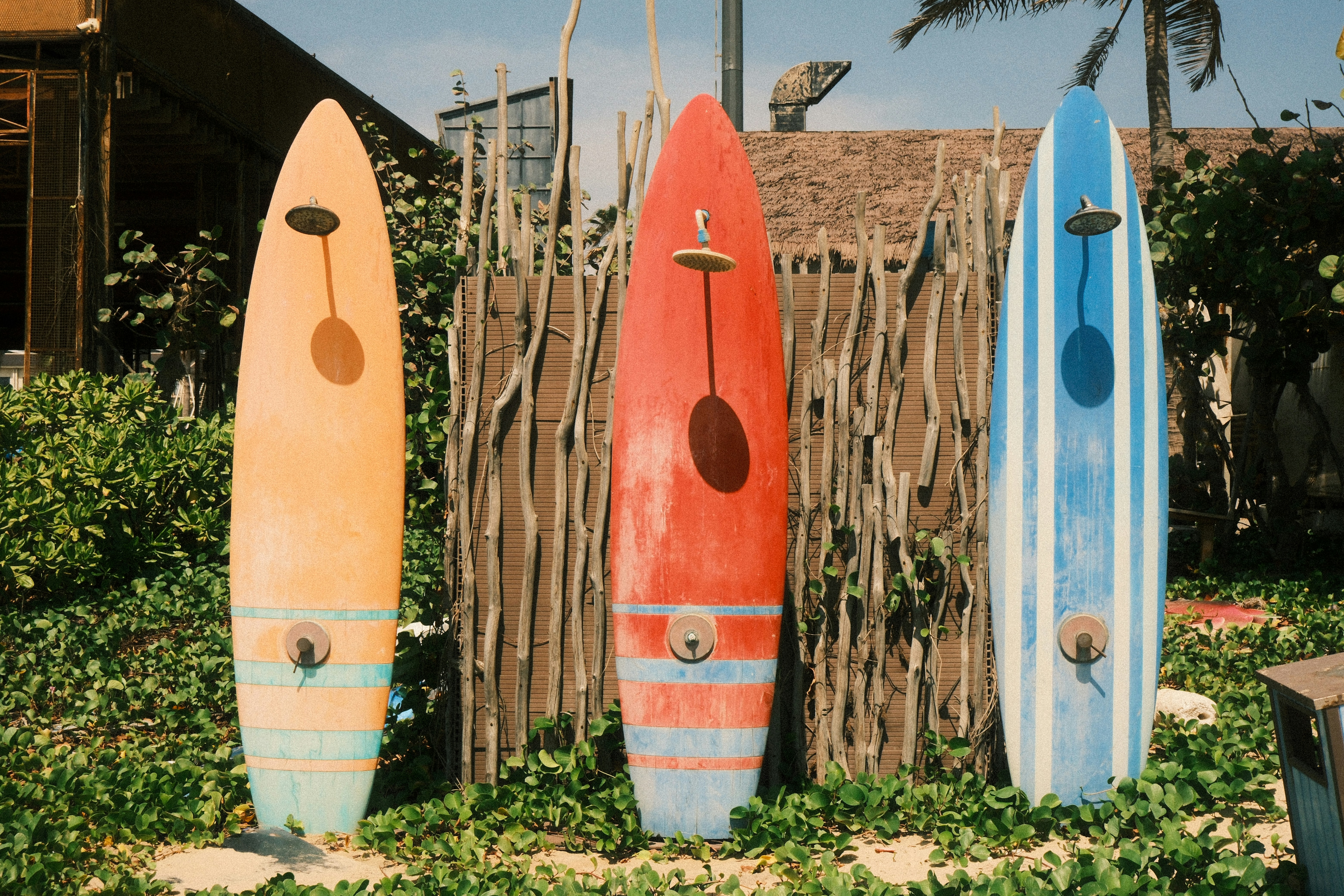 Triad of Painted Surfboards: Sunset Guardians on Coastal Sand