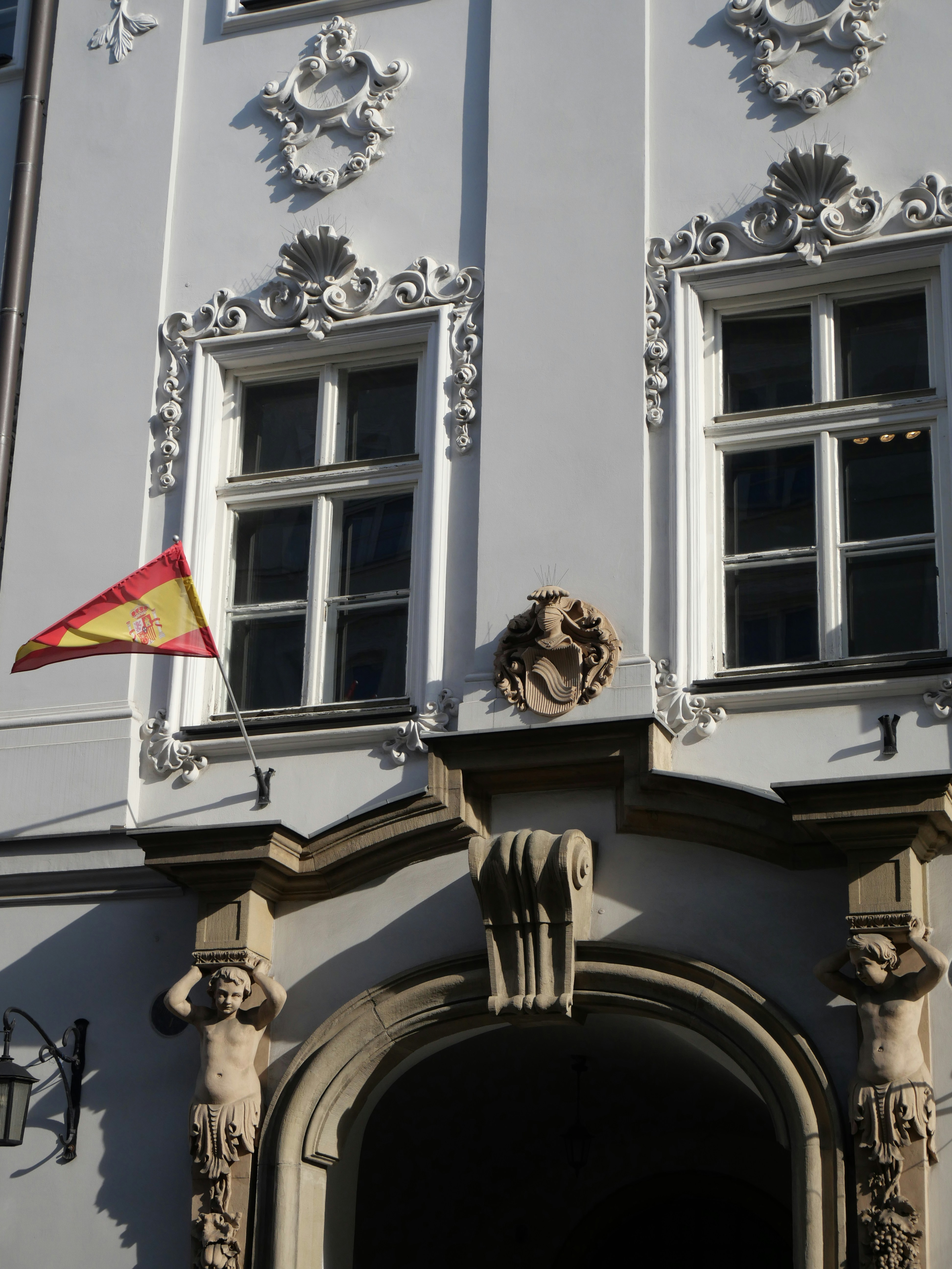 Ornate Facade Watch: A Spanish Town Hall with Flag on Classical Reliefs