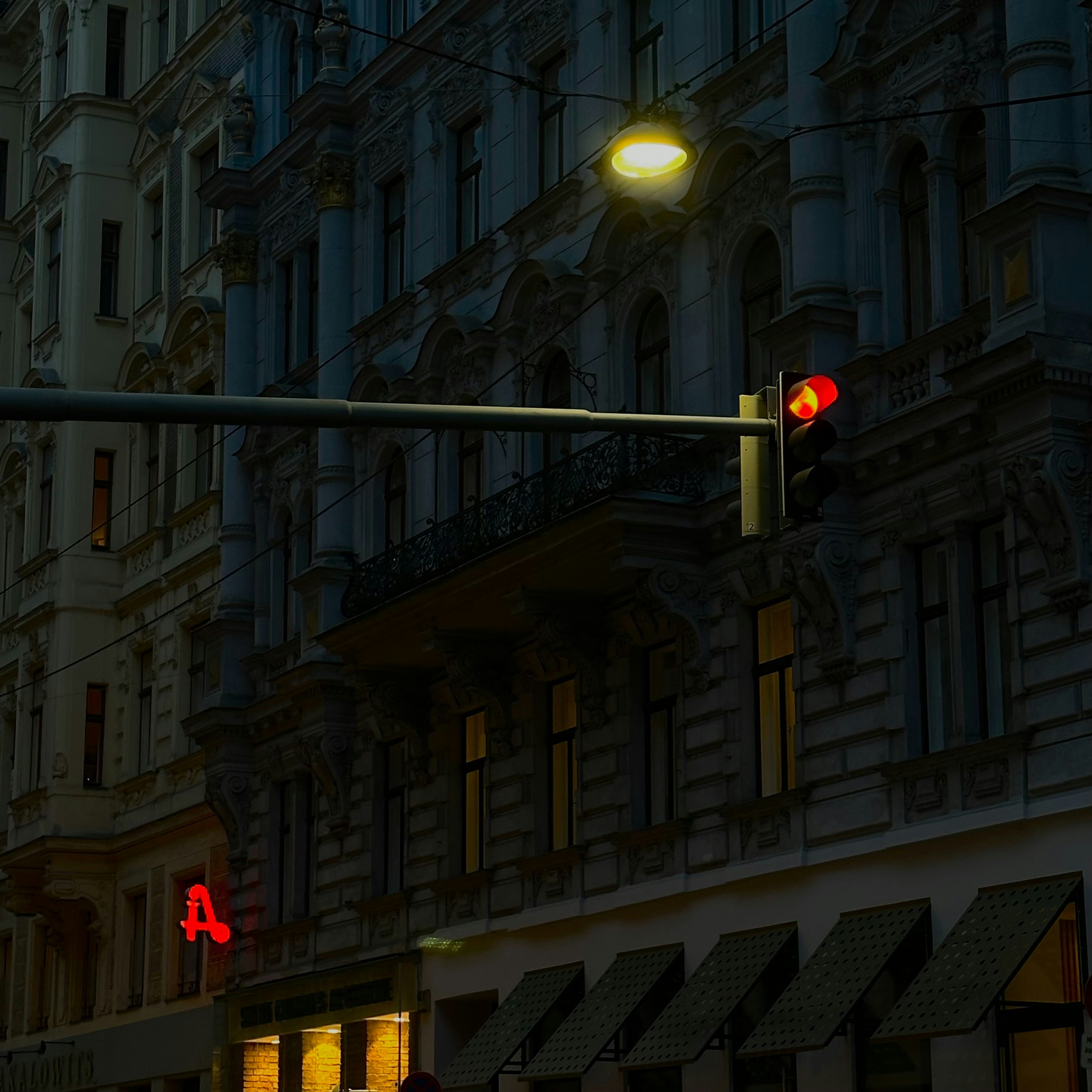 Urban Midnight: Neon Signage and Red Light at a Facade