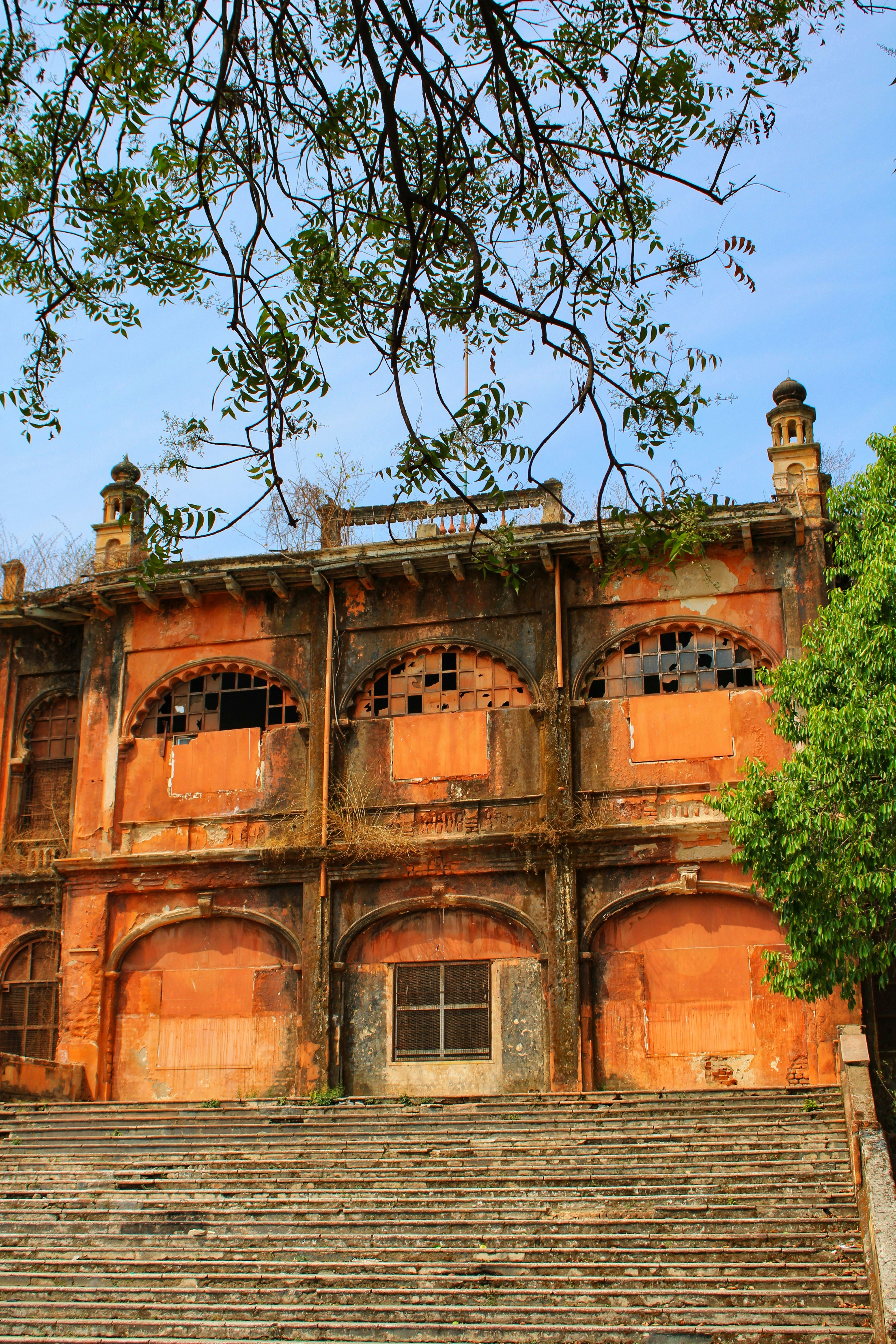 Forgotten Facade: Red Brick Arches and Weathered Stairs