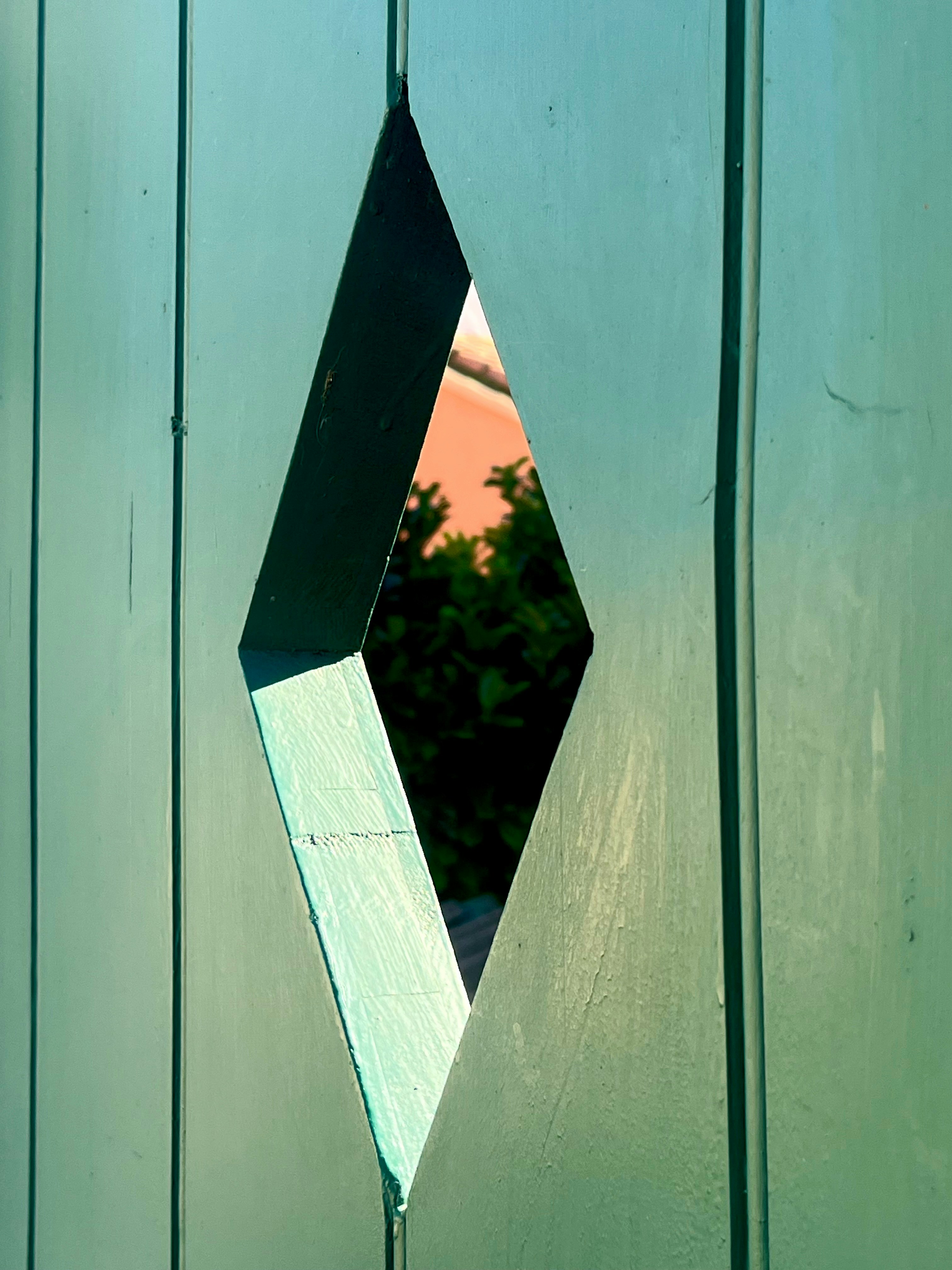 Emerald doorway: a geometric diamond opening in teal shutters