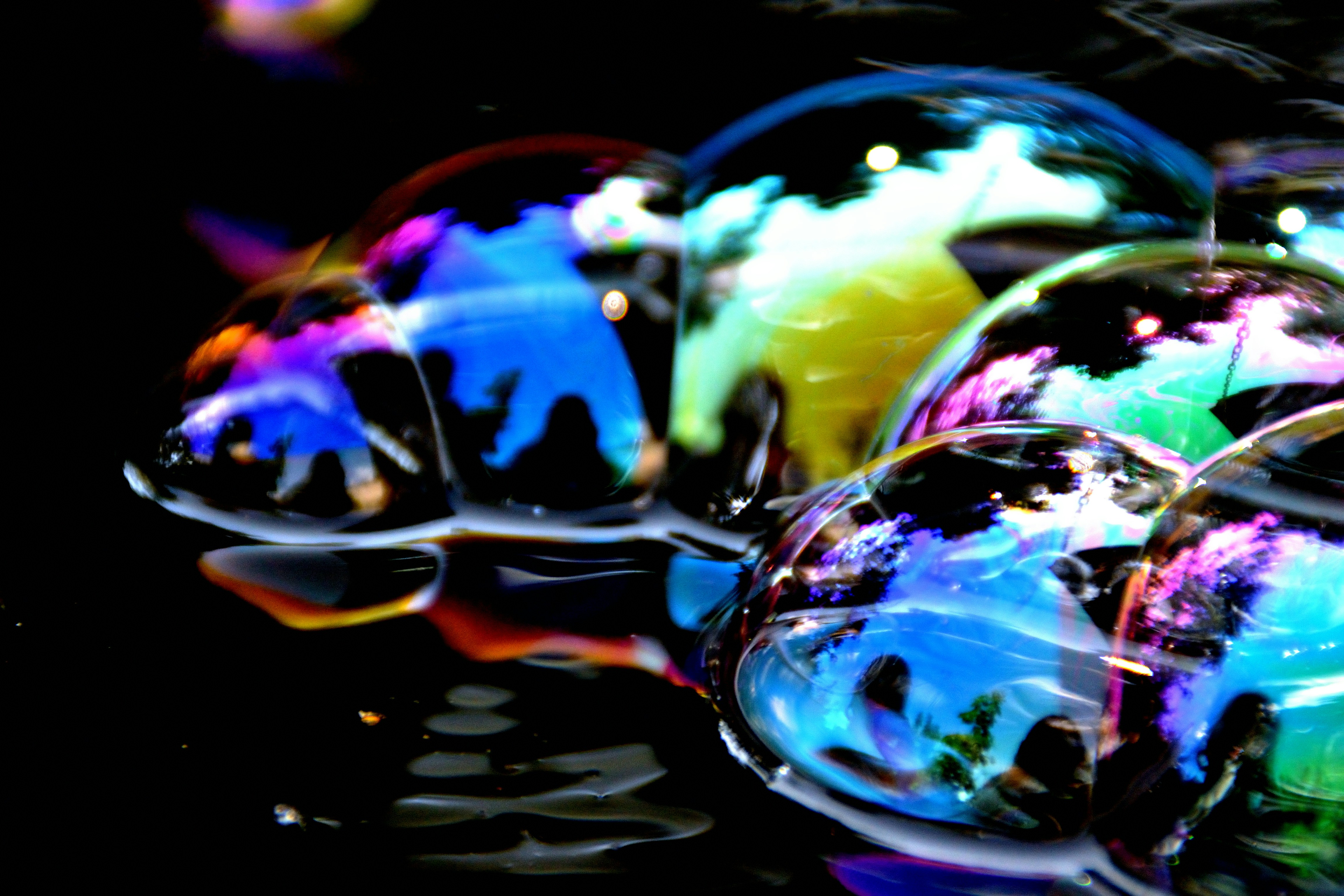 Bubbles in Color: Neon Orbs Dancing on a Dark Surface