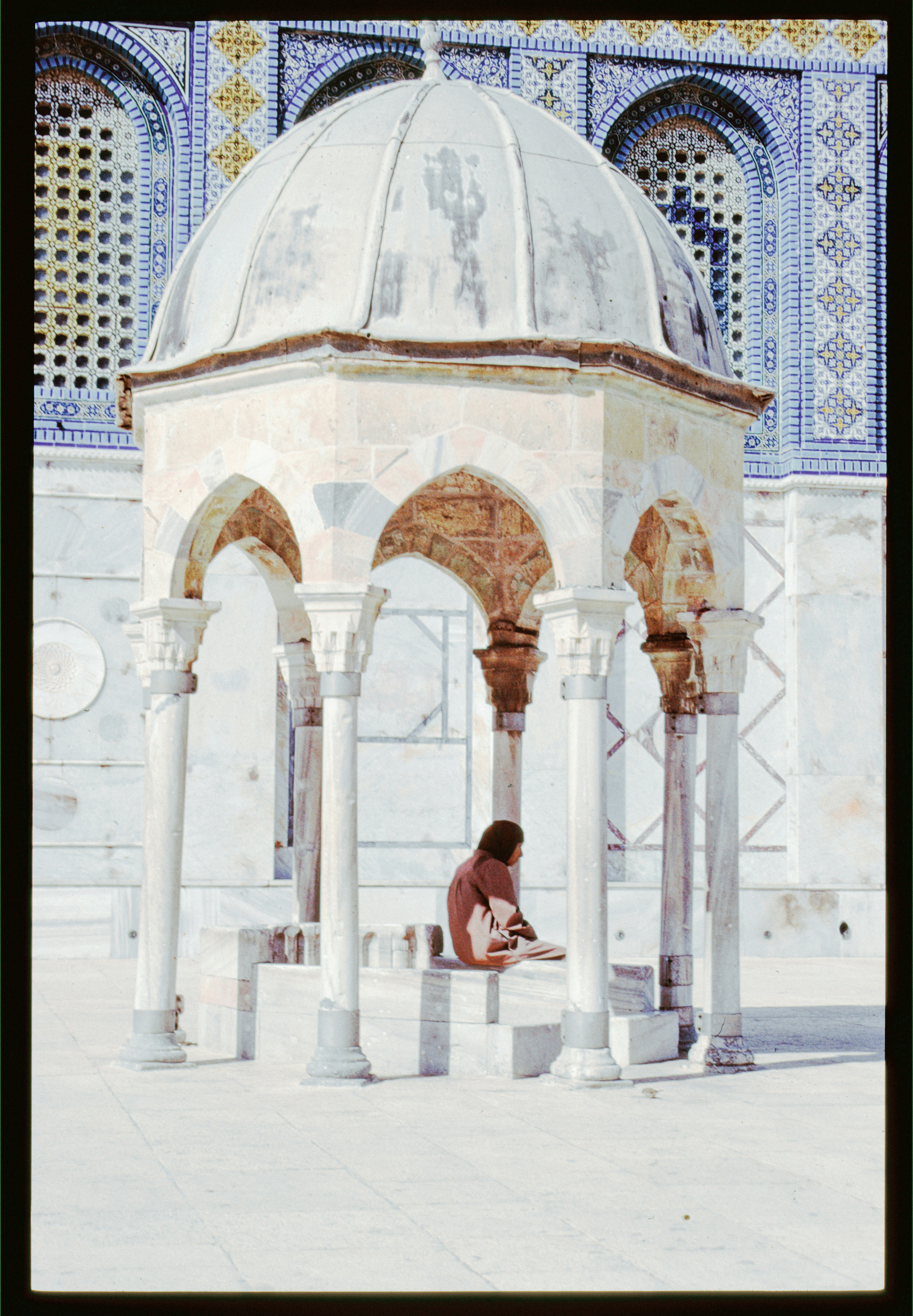 Quiet Shrine: A Seated Figure Beneath Marble Arches