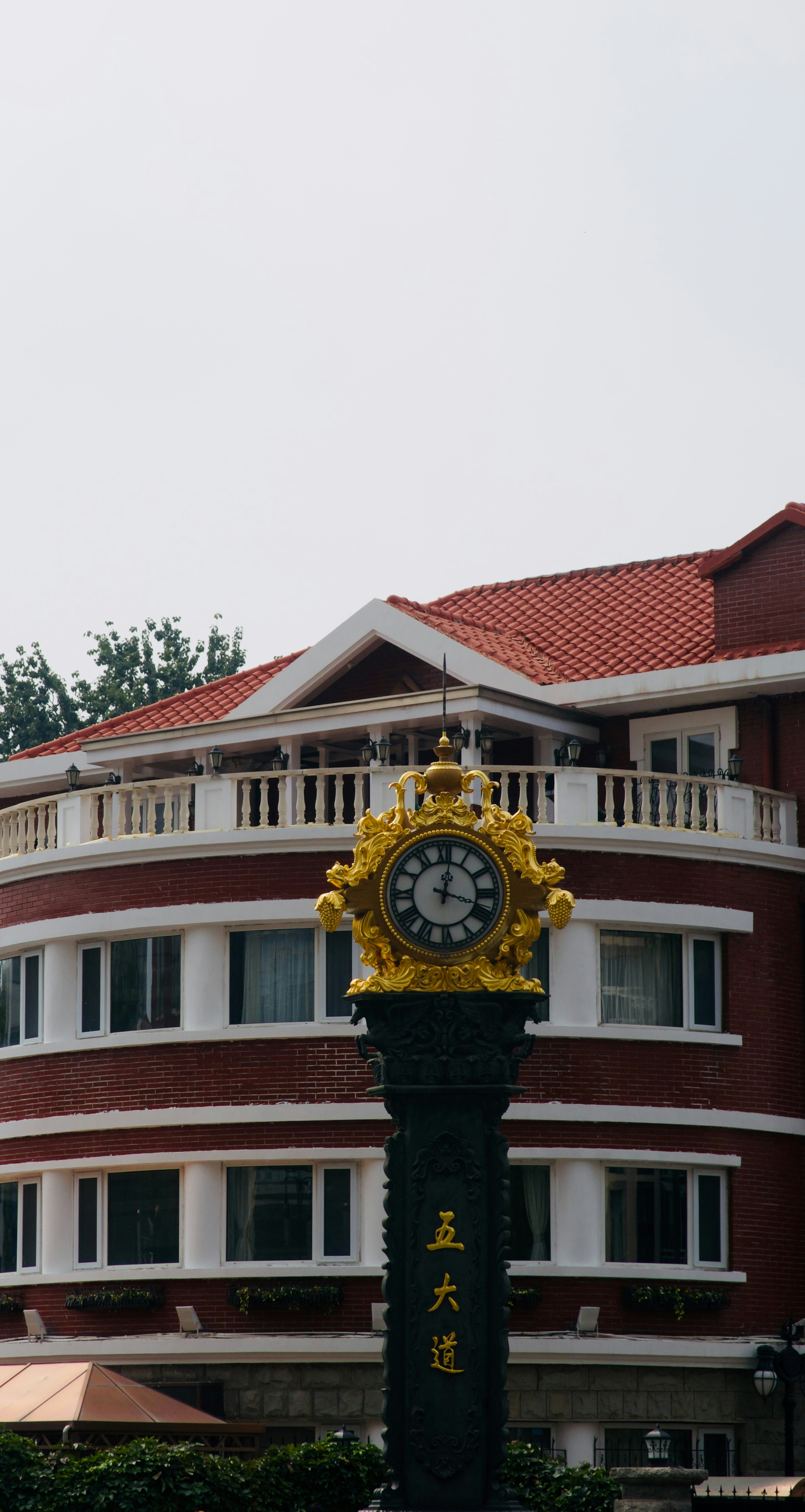 Golden Clocktower Standing Guard in Front of Red Brick Crescent