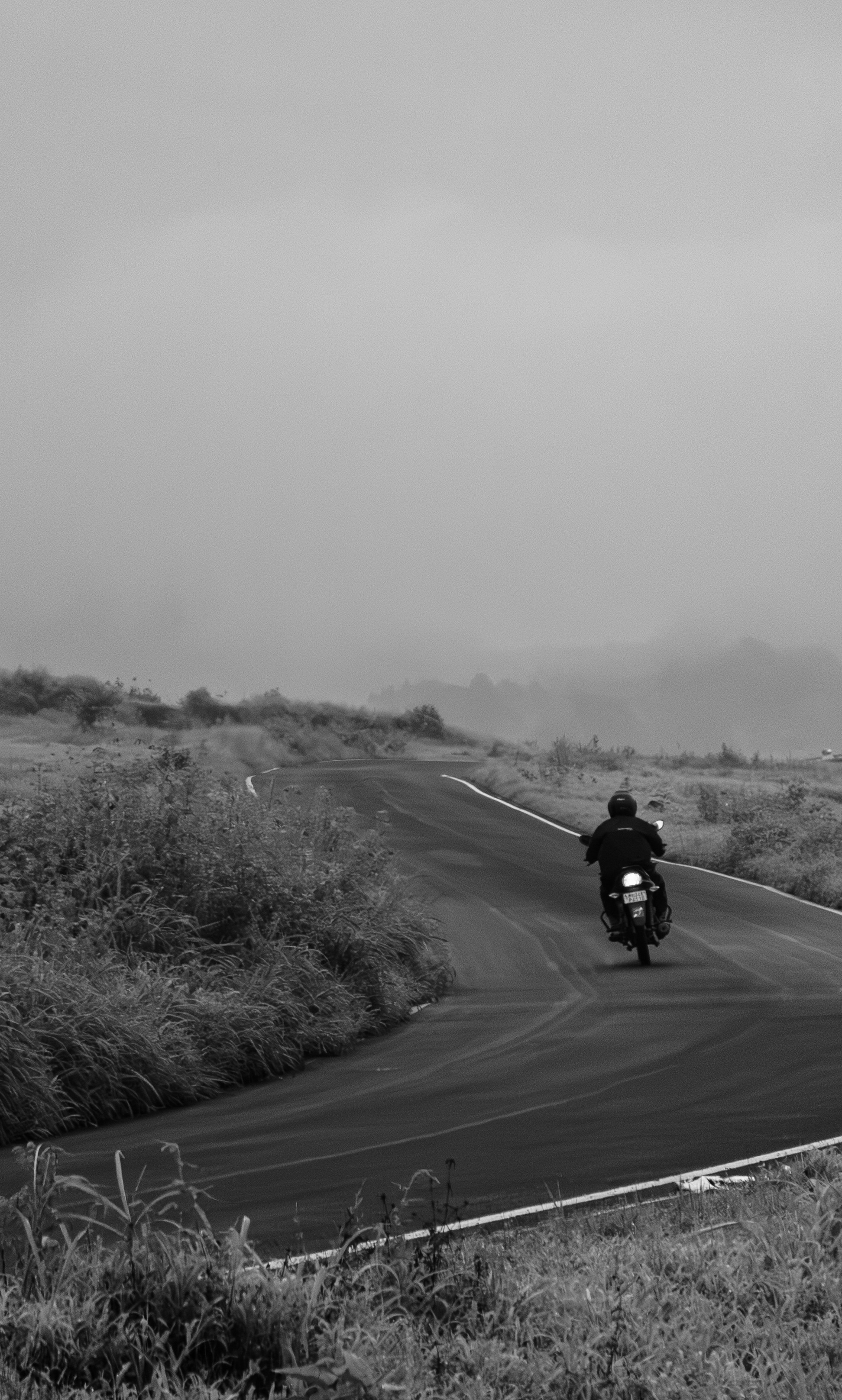 Curved Road, Lone Rider: A Quiet Journey Through Dusk