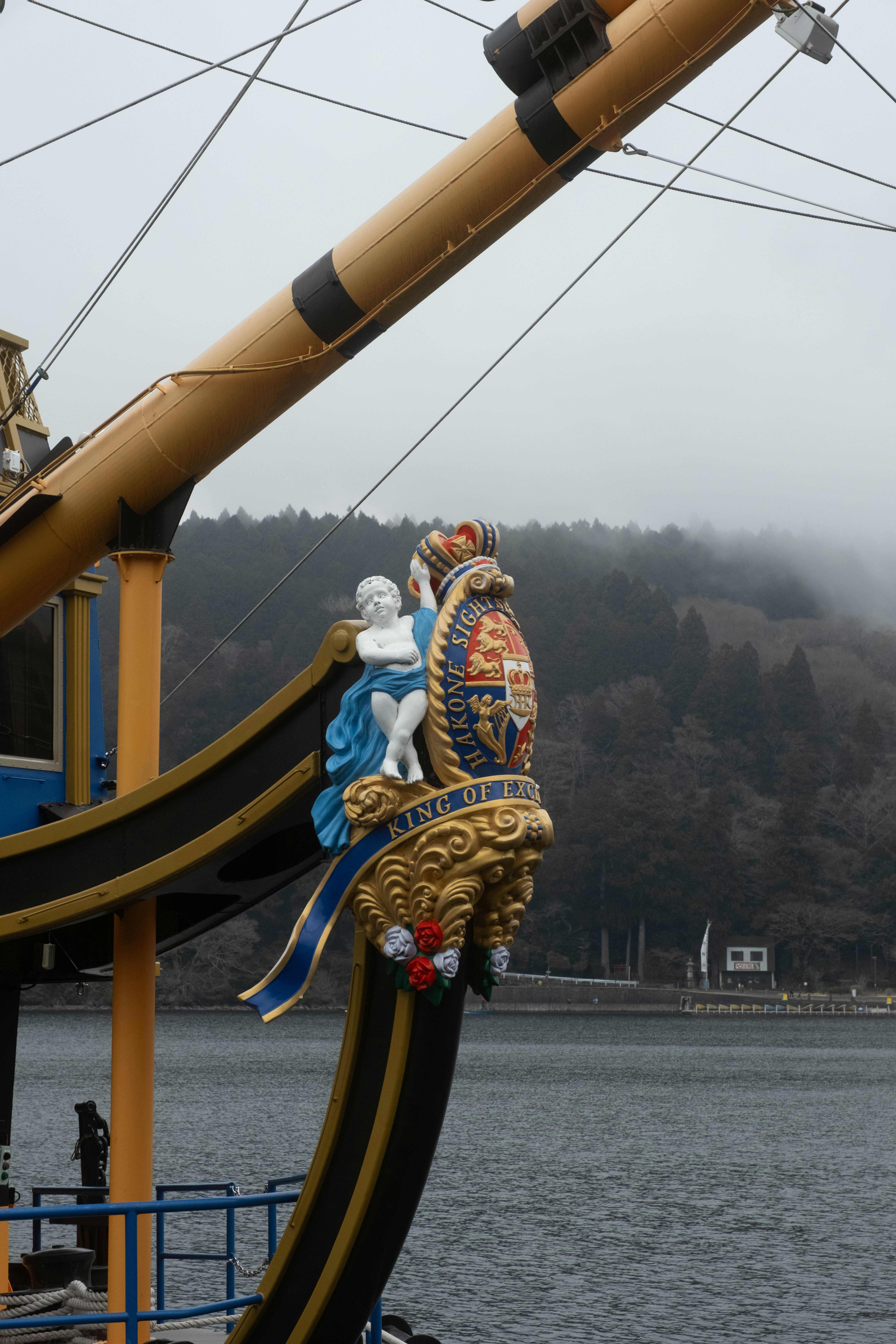 Ornate Dragon Carving Adorns a Traditional Vessel Framing a Misty Shore