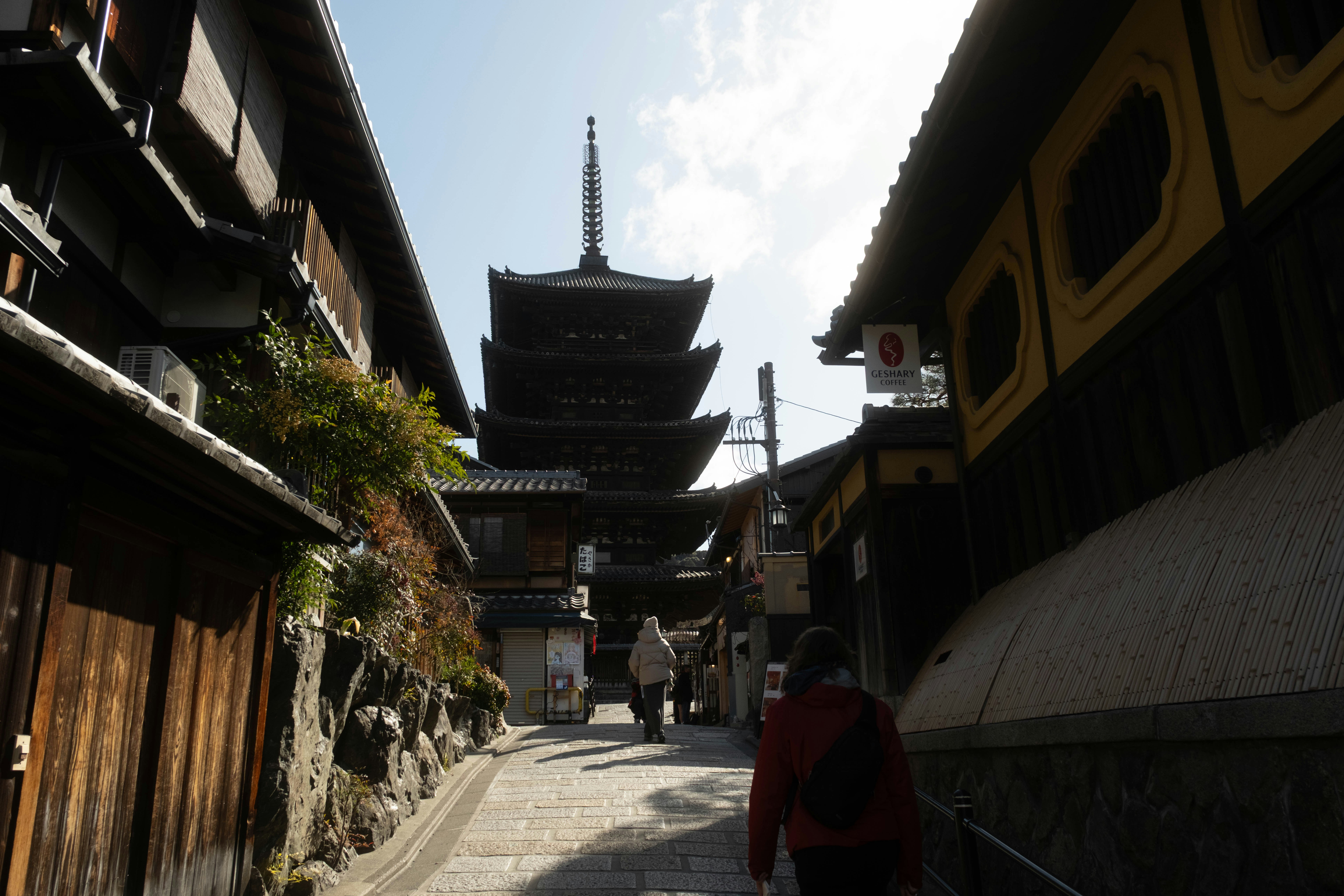 A traditional japanese street with a pagoda in the distance.